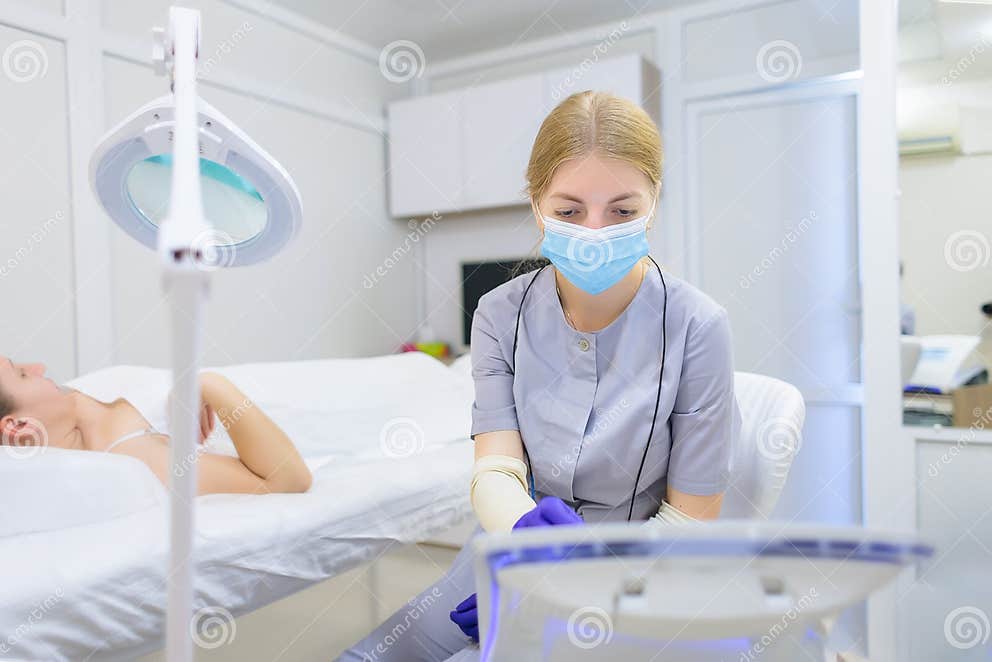 The Electroepilation Master Sits at the Workplace and Sets Up the ...