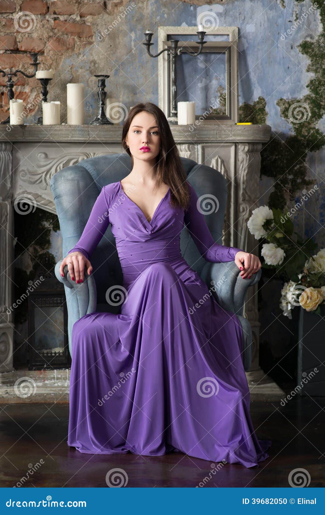 Elegance Woman In Long Violet Dress Sitting On Chair Indoor Stock