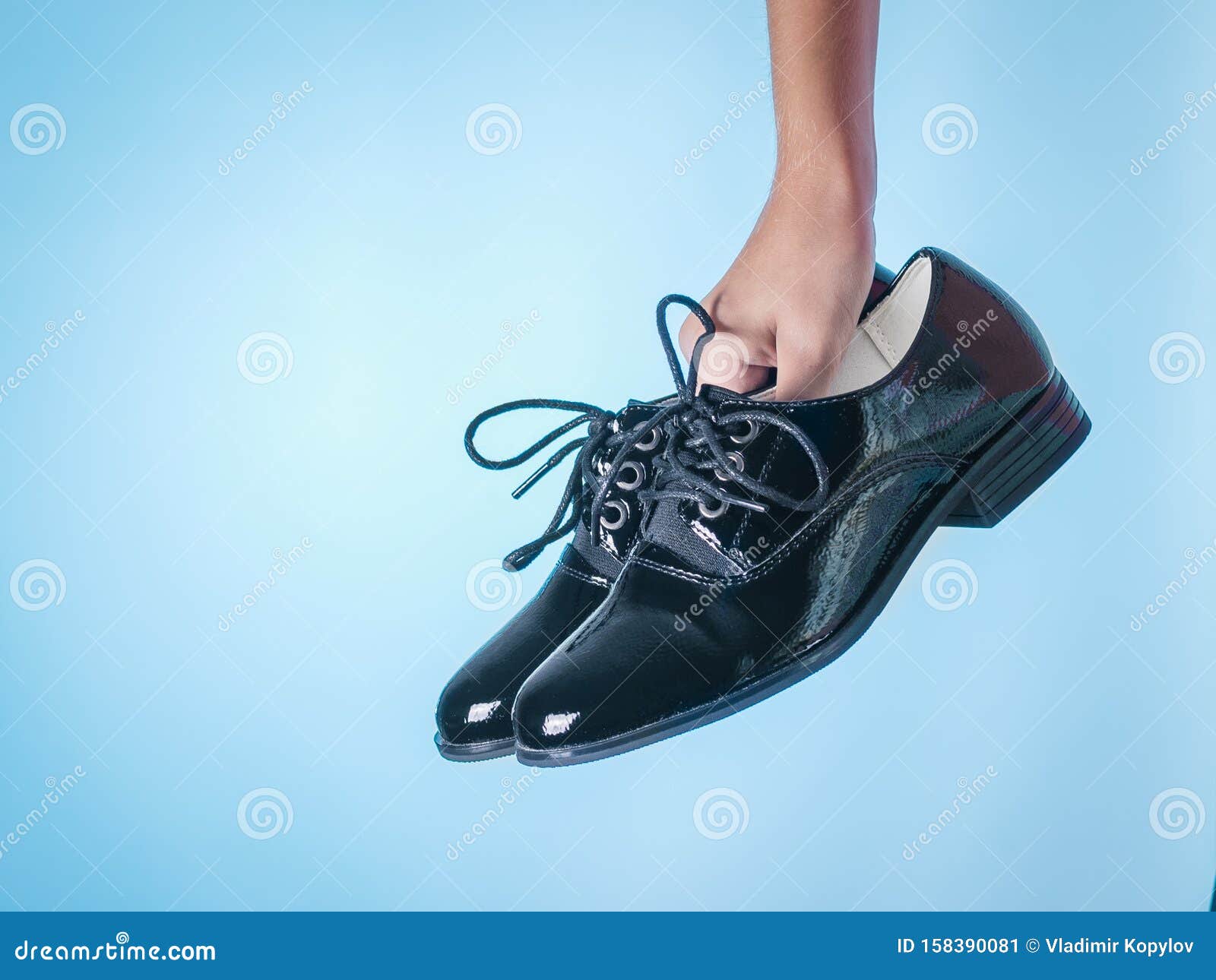 Elegant High Heels with Laces in the Hands on a Blue Background. Stock ... Elegant High Heels with Laces in the Hands on a Blue Background. Stock ...