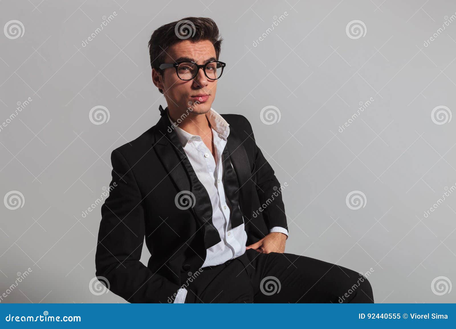Elegant Man With Undone Bowtie And Glasses Sitting Stock Image - Image ...