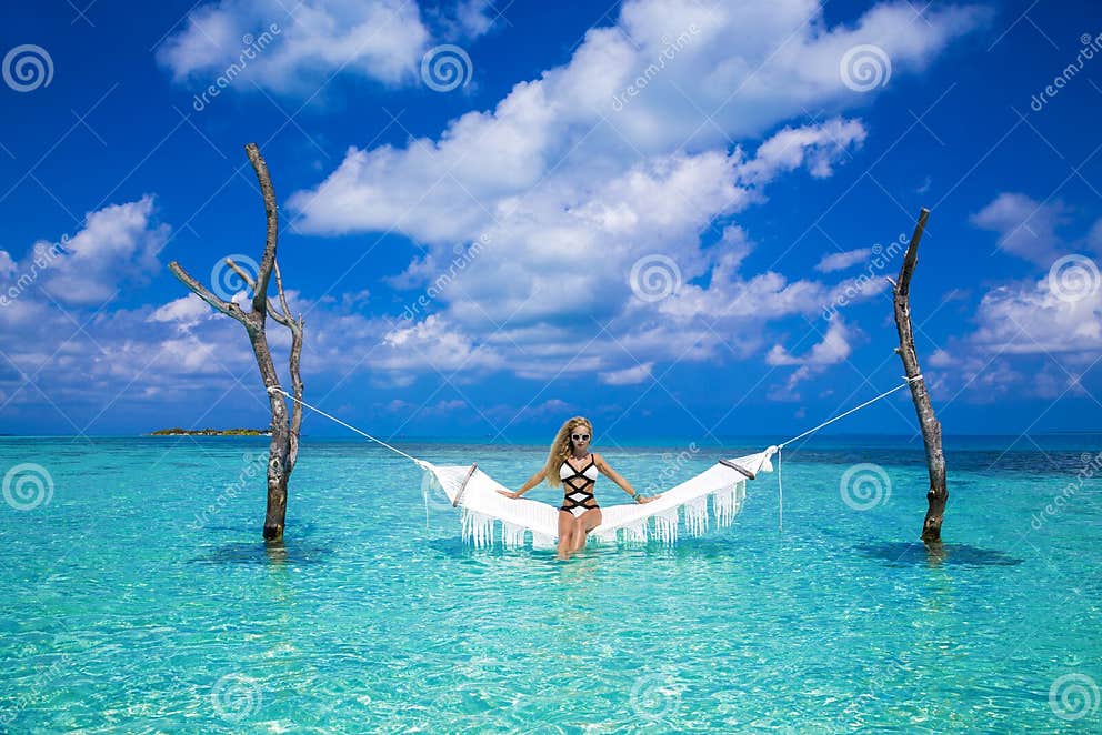 Elegant Woman In The White Bikini On The Sun Tanned Slim And Shapely