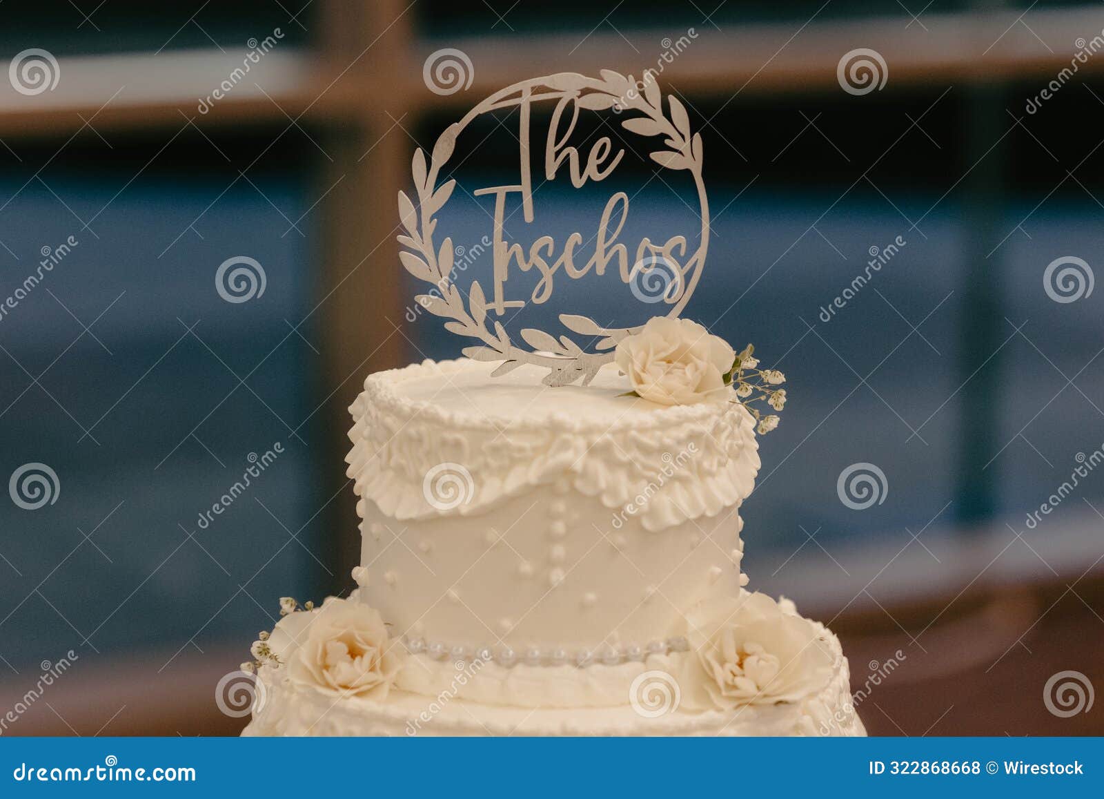 A White Wedding Cake with a Decorative Topper is on a Table Stock Photo ...
