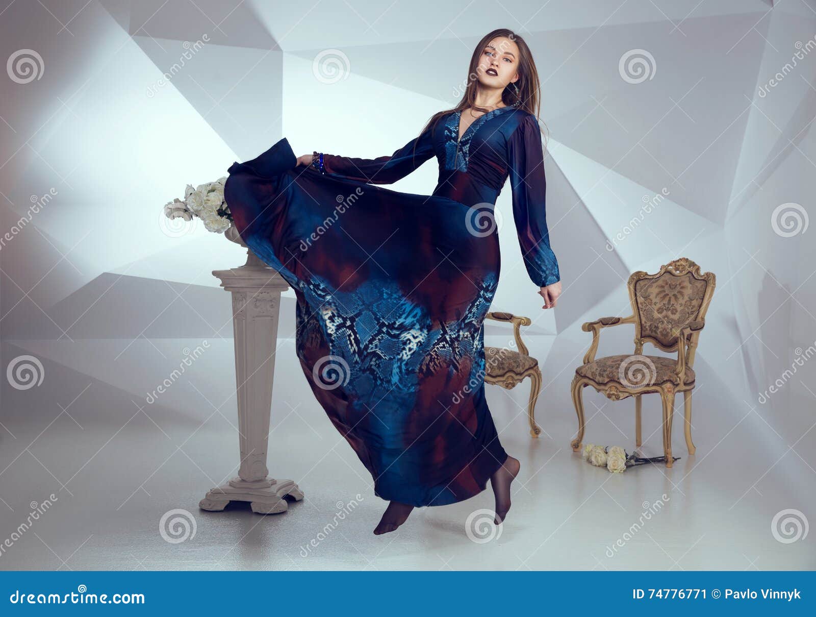 Elegant Woman in a Long Dress Jumping on Background of White Geometric ...