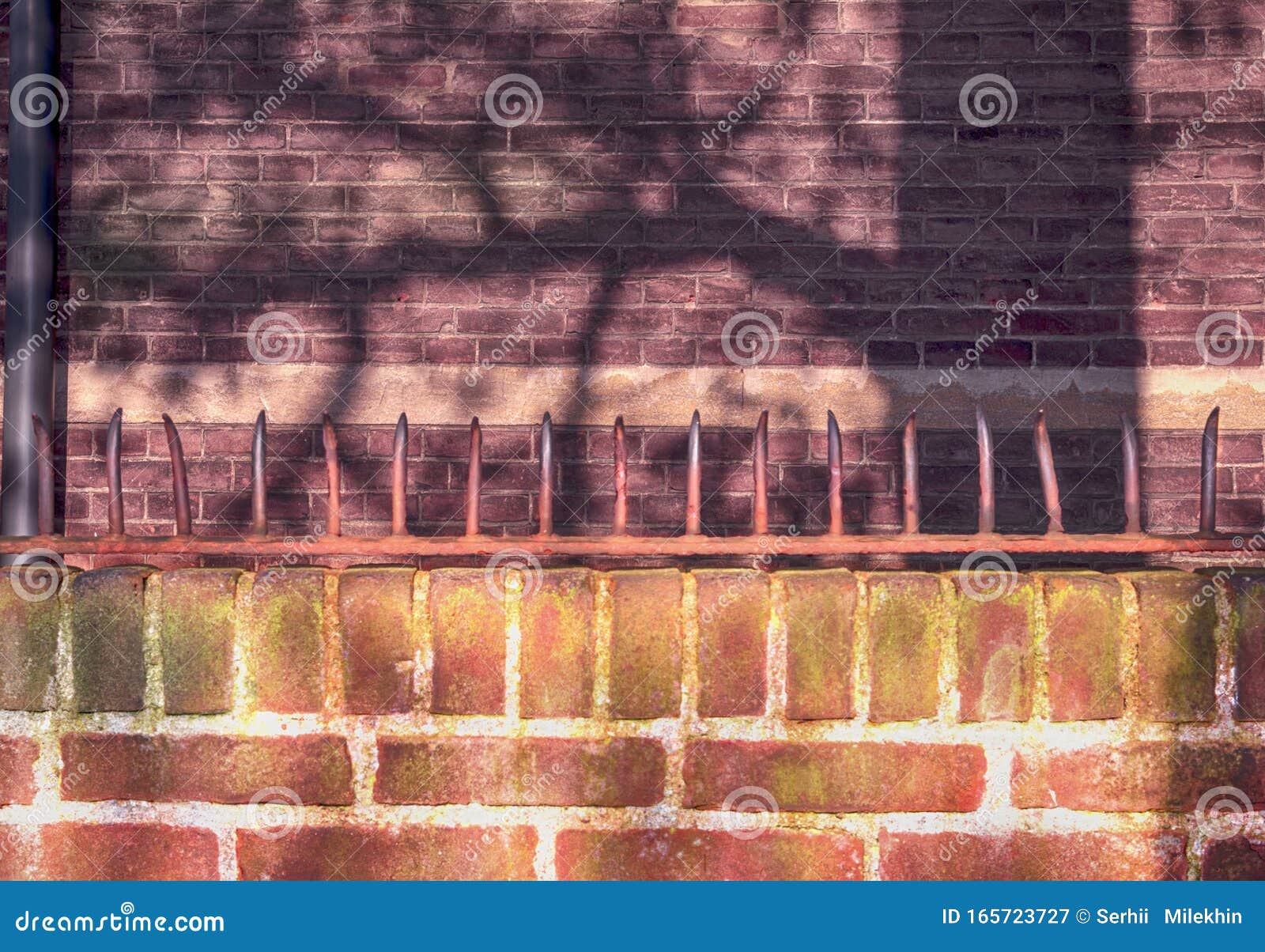 Element of a Brick Fence with Metal Spikes on a Background of an Old ...