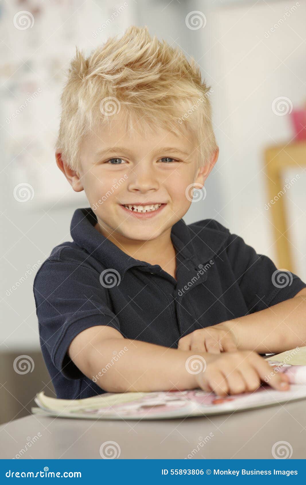 Elementary Age Schoolboy Reading Book in Class Stock Photo - Image of ...