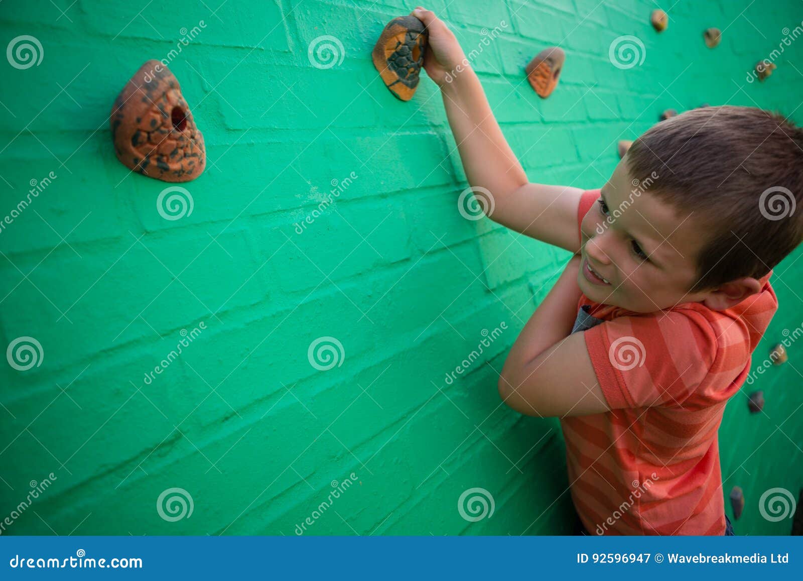 Elementary Boy Climbing on Brick Wall Stock Image - Image of ...