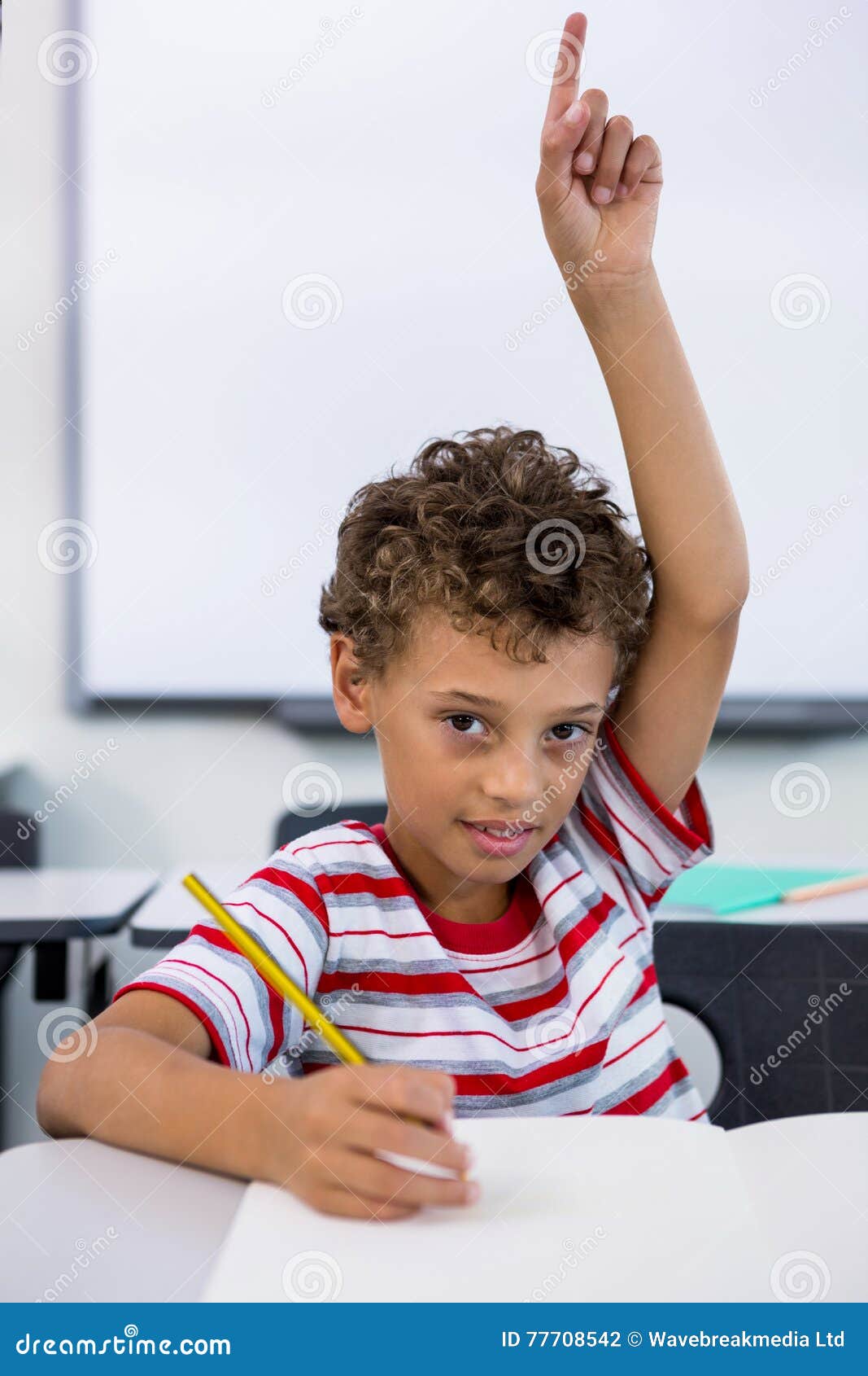 Elementary Boy Raising Hand in Classroom Stock Photo - Image of looking ...