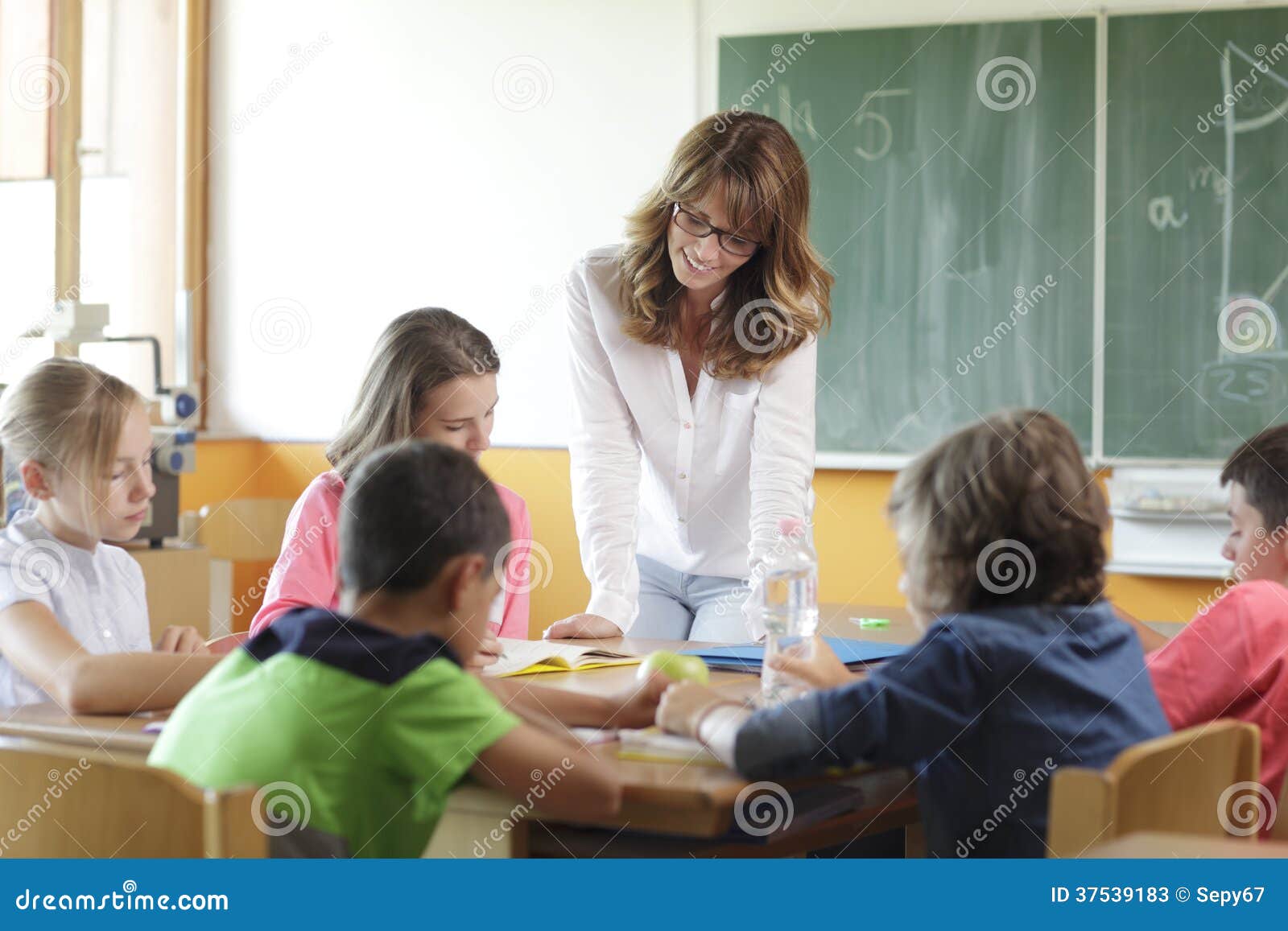 Elementary Classroom Setting Focus On Teacher And Chalkboard Stock