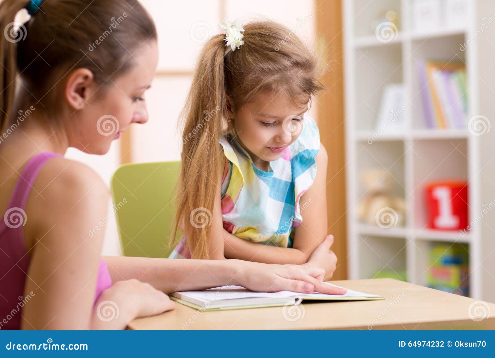 Elementary Pupil Reading with Teacher Stock Photo - Image of preschool ...