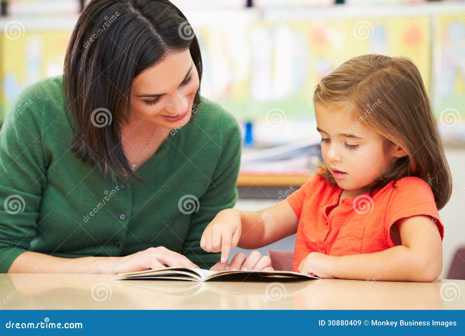 Elementary Pupil Reading with Teacher in Classroom Stock Image - Image ...