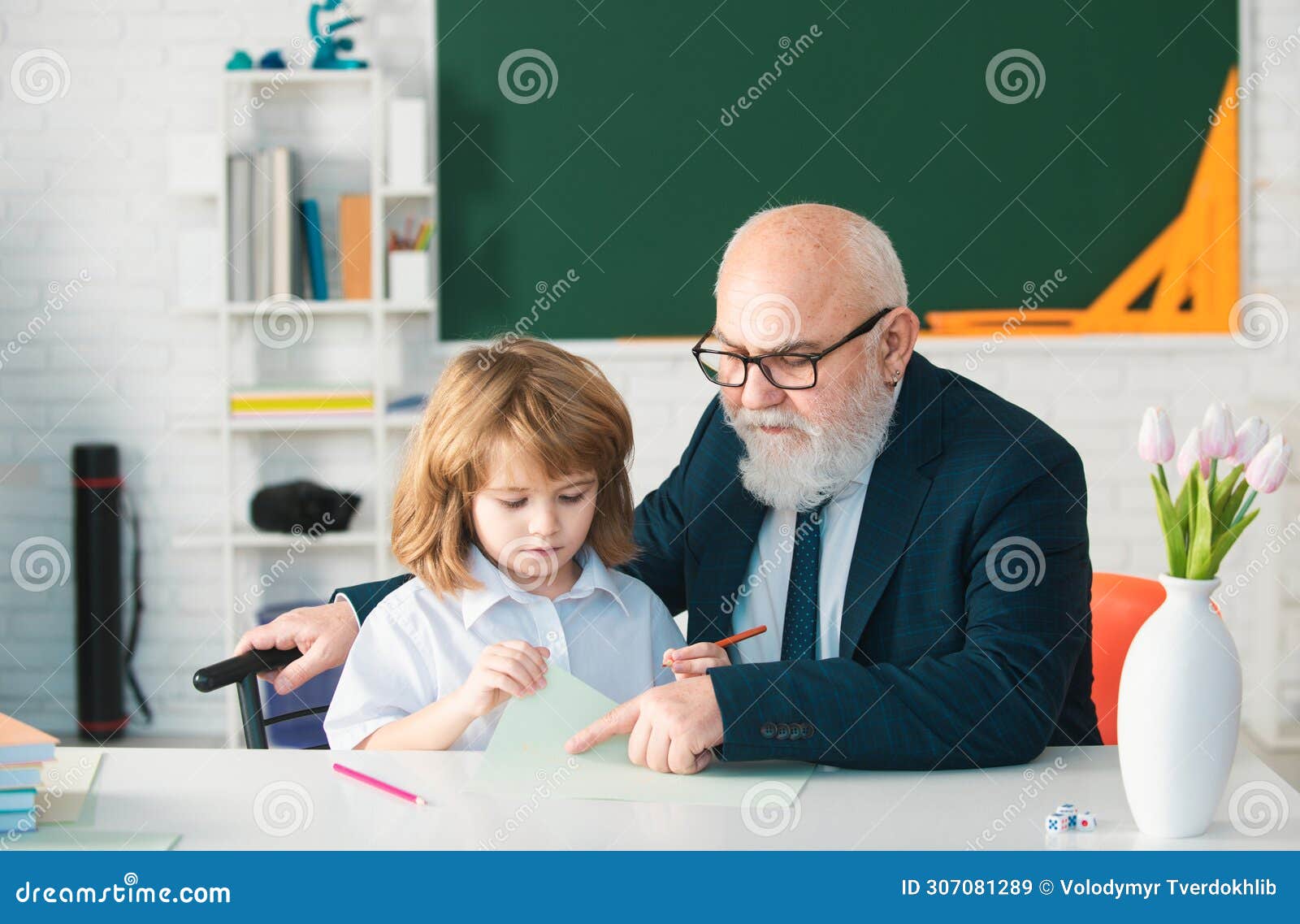 Elementary Pupil Reading and Writing with Teacher in Classroom. Old ...