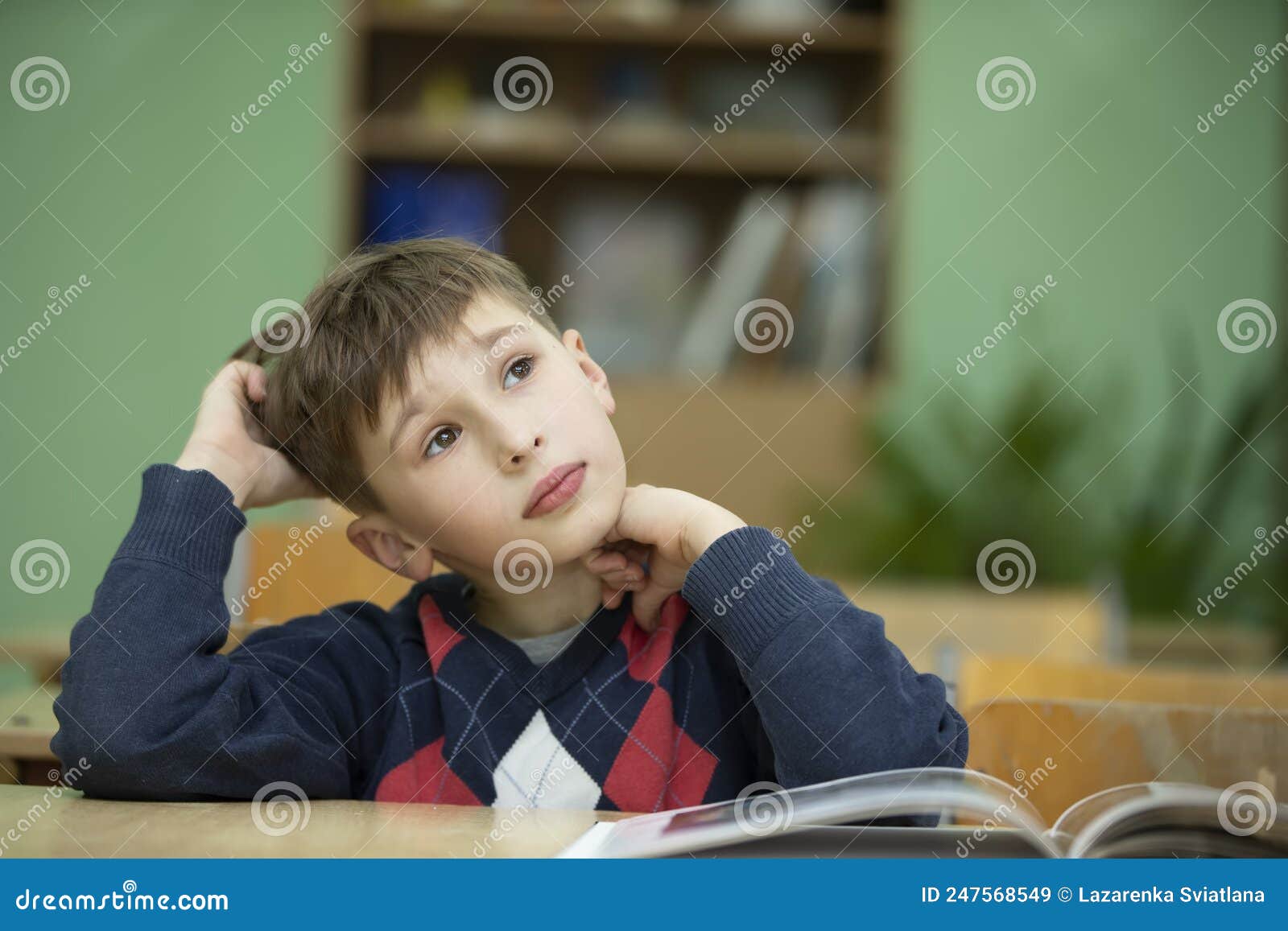 Elementary School Boy in a Classroom with a Book Stock Image - Image of ...
