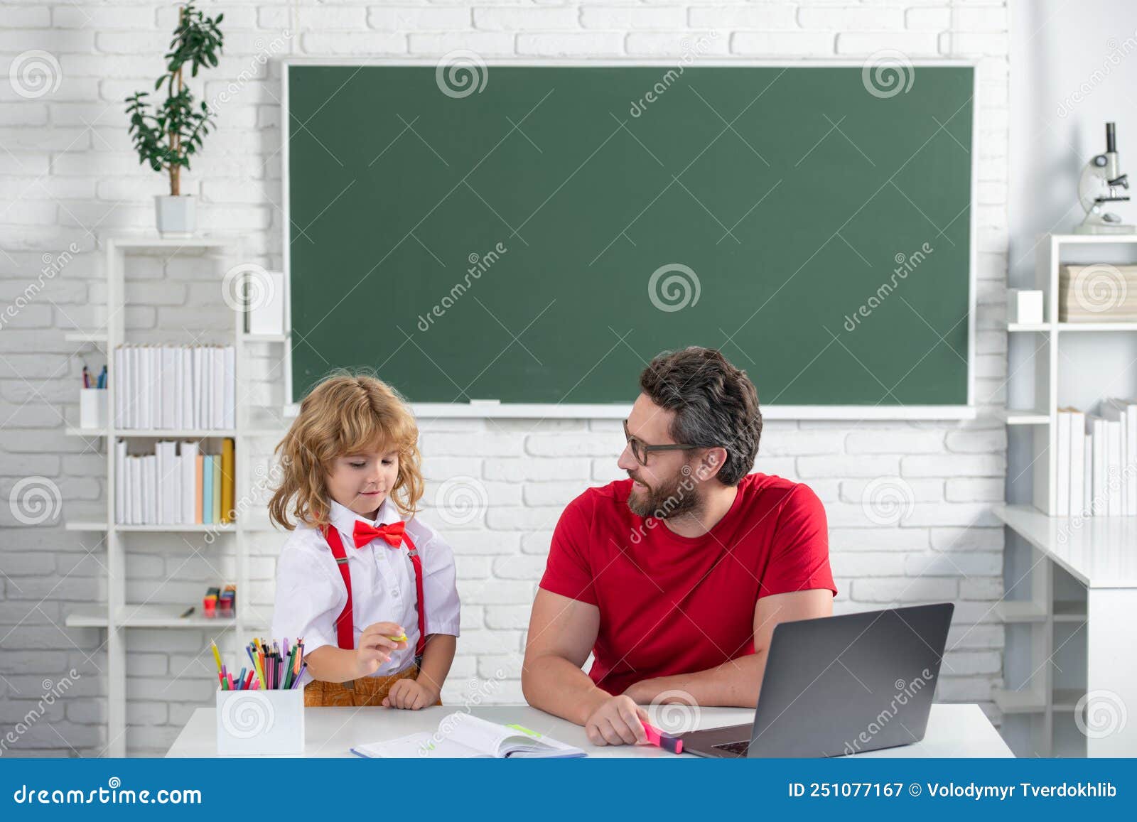 Elementary School Boy in Classroom on Lesson. Teacher Explaining To ...