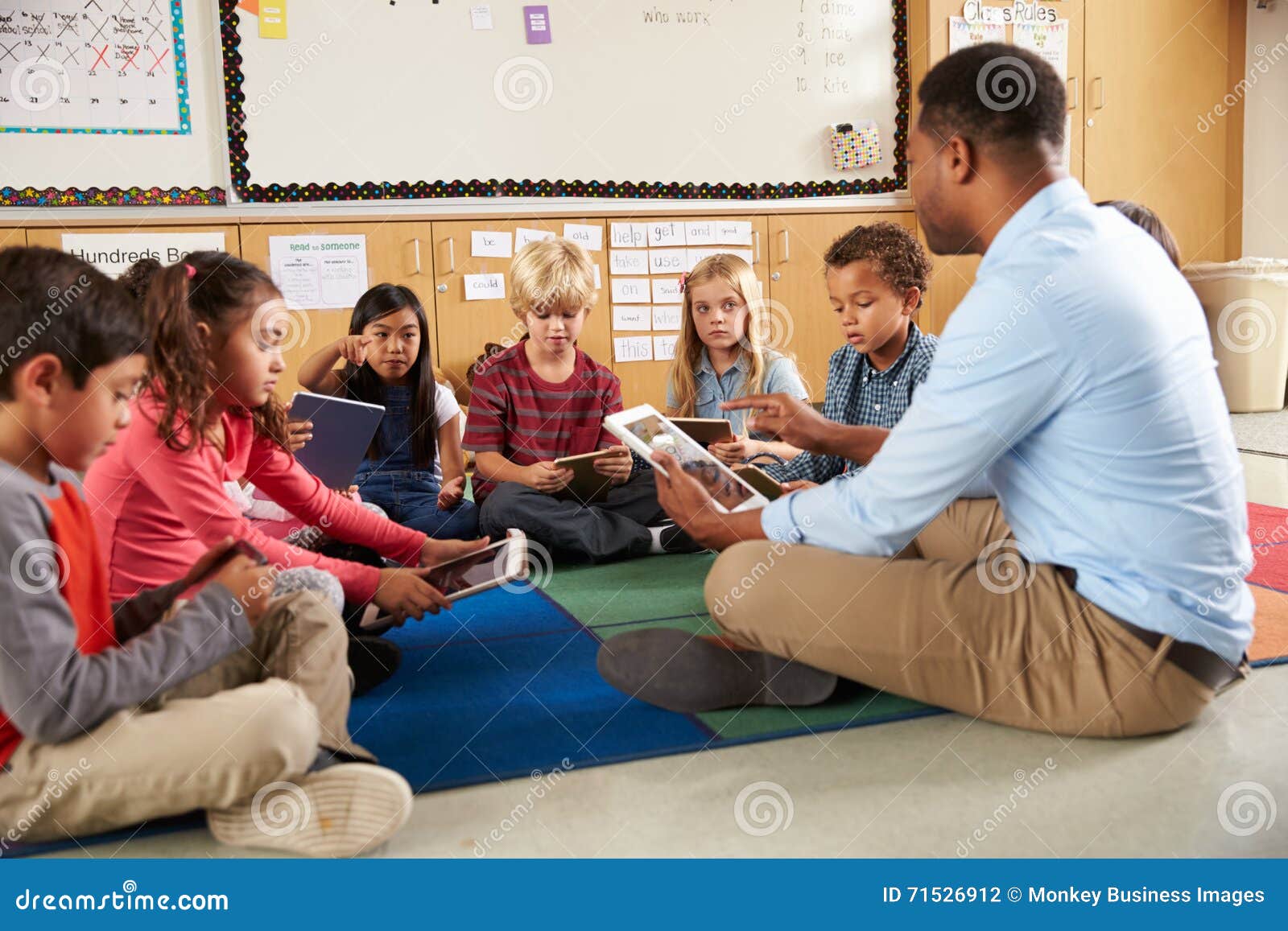 Elementary School Class Sitting Cross Legged Using Tablets Stock Photo ...