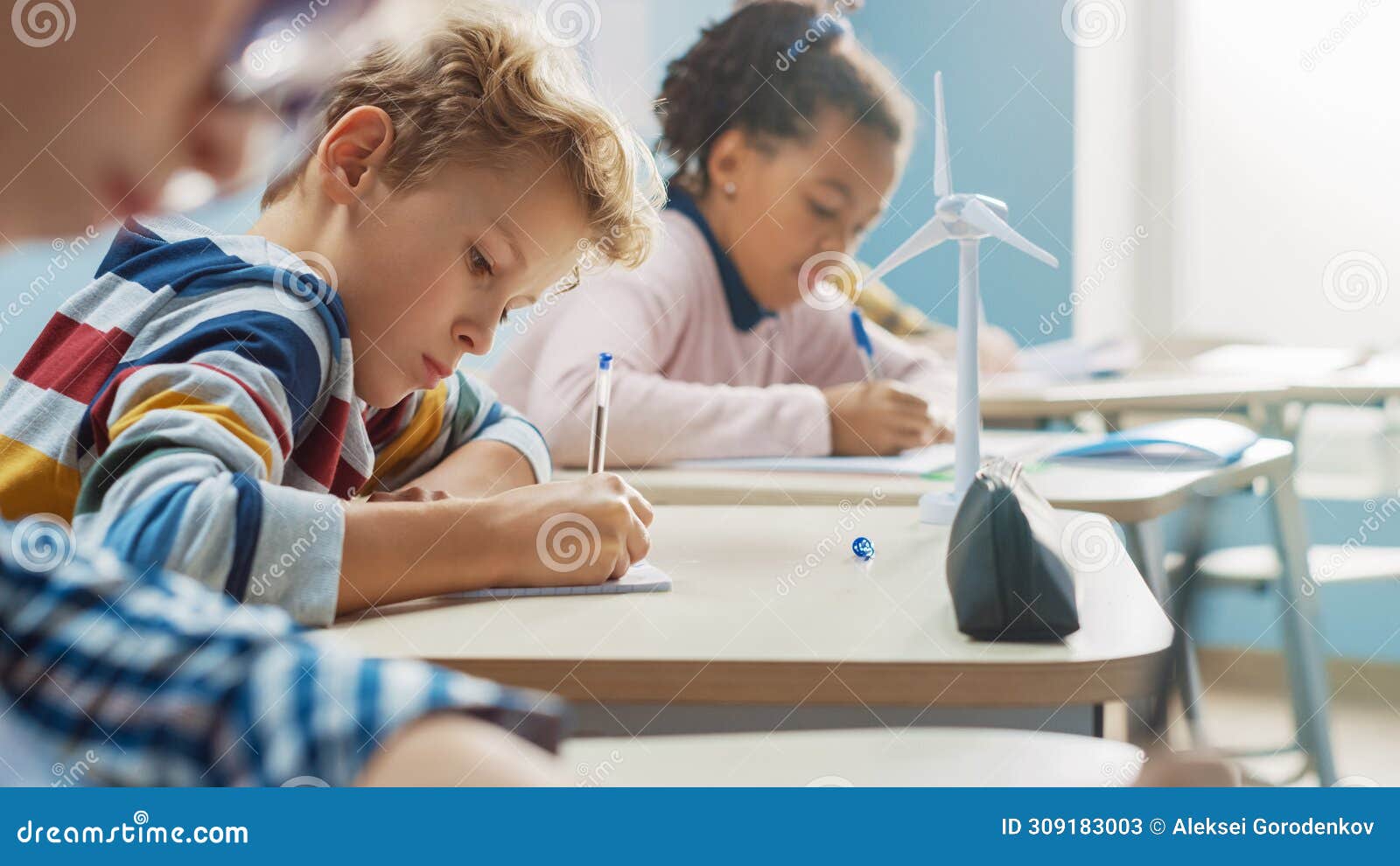 In Elementary School Classroom Brilliant Caucasian Boy Writes in ...