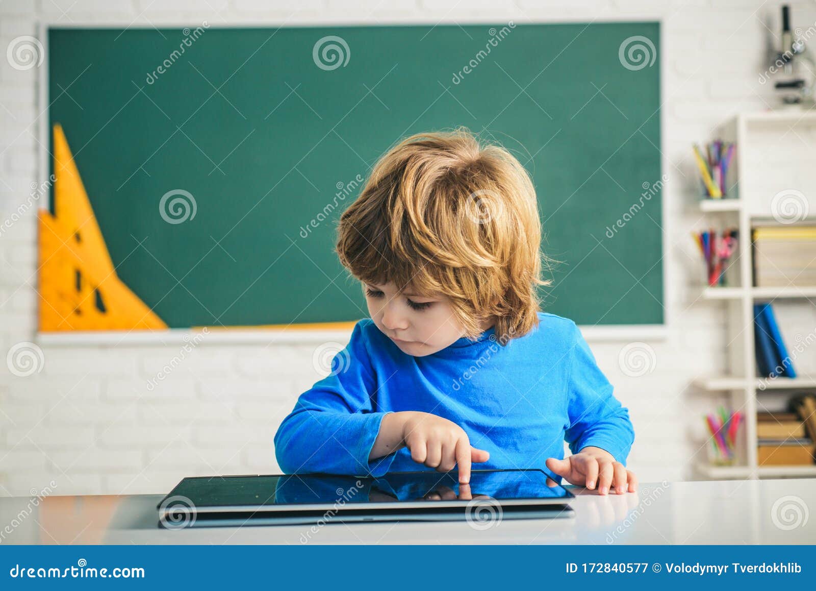 Elementary School and Education. Little Boy Playing with Digital Tablet ...