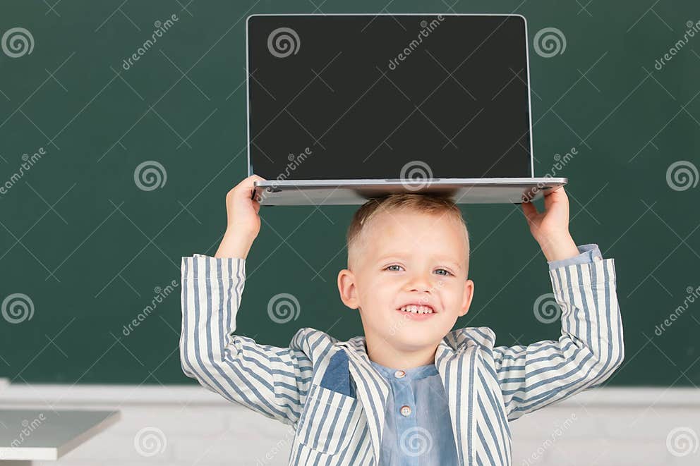 Elementary School Kid Holding Laptop on Head in Computer Class. Stock ...
