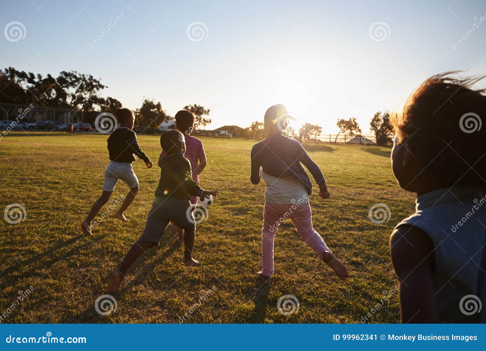 Elementary School Kids Playing Football In A Field, Back View Stock ...