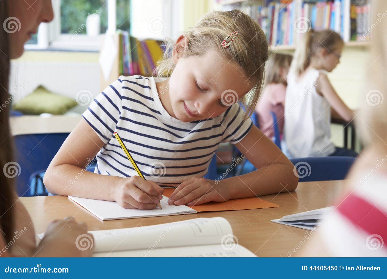 Elementary School Pupil Working at Desk in Classroom Stock Photo ...