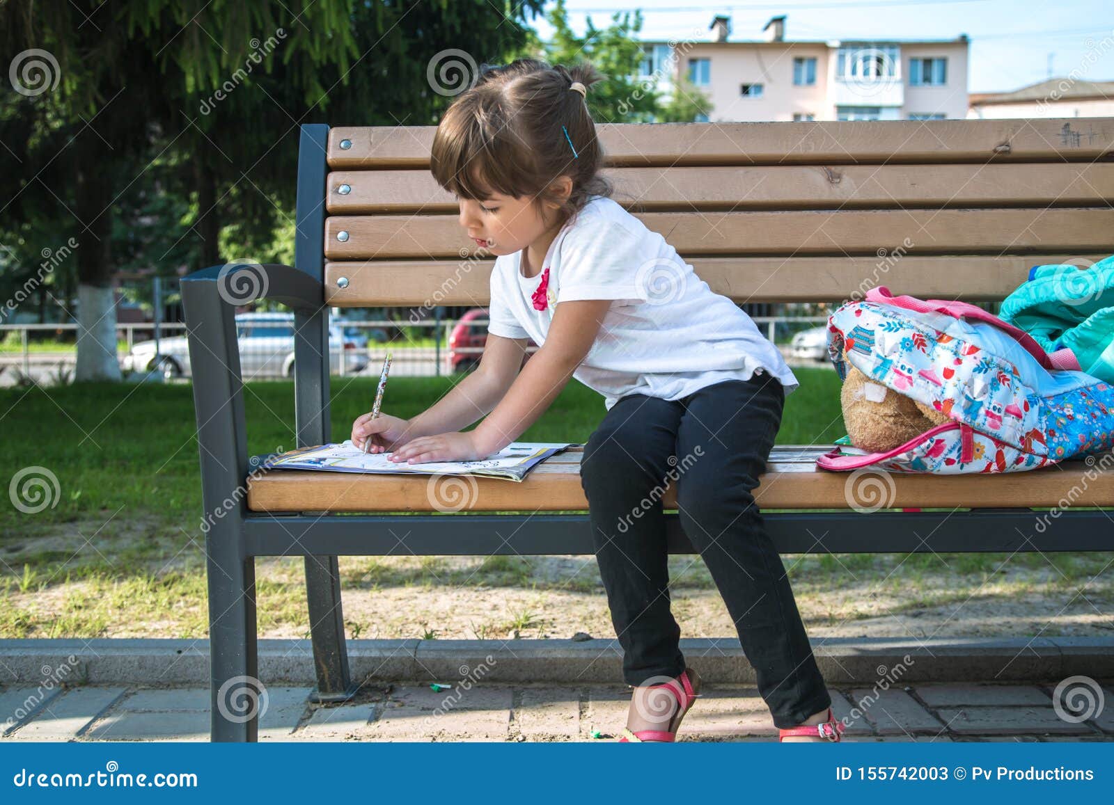 An Elementary School Student with a Backpack is Sitting on a Bench and ...