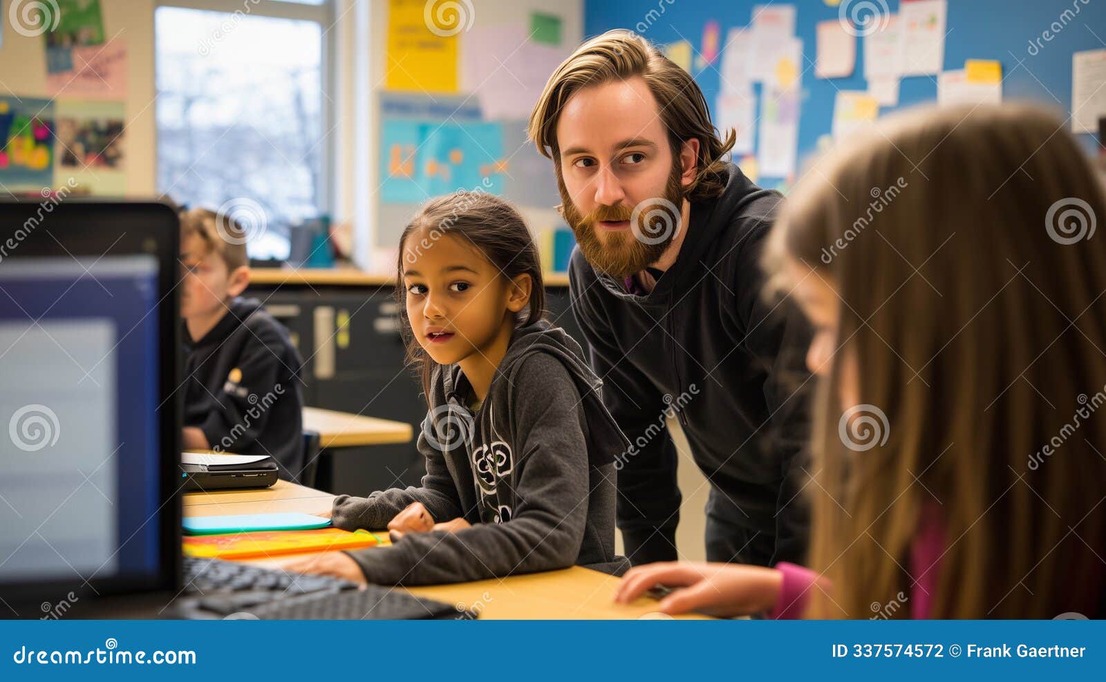 Elementary School Teacher Assisting Students in a Classroom with ...