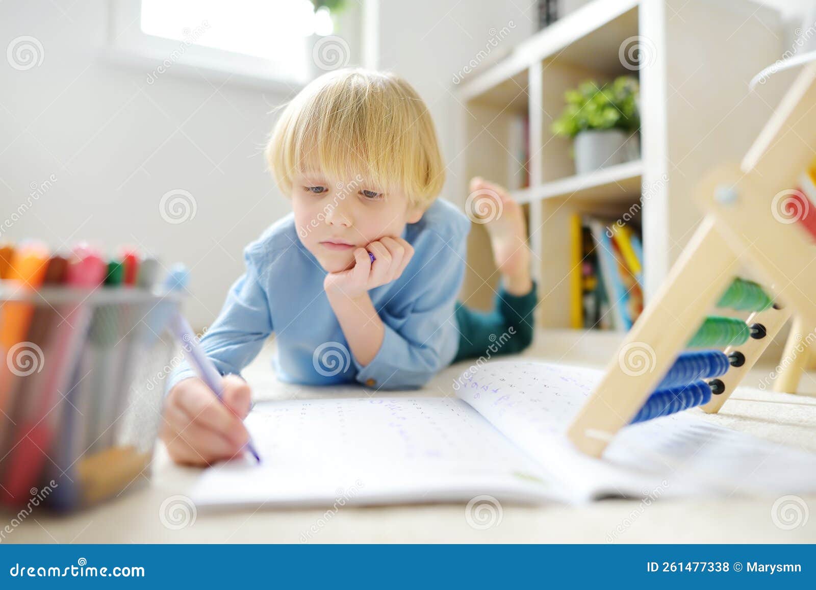 Elementary Student Boy Doing Homework on Floor at Home. Child Learning ...