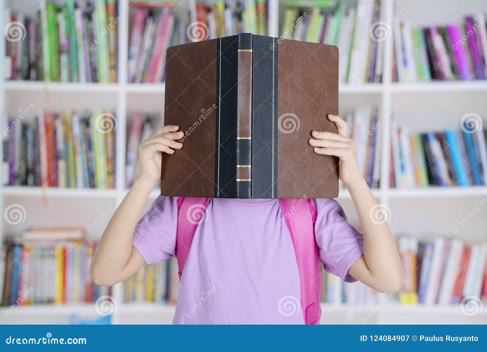 Elementary Student Hides Her Face Behind a Book Stock Image - Image of ...