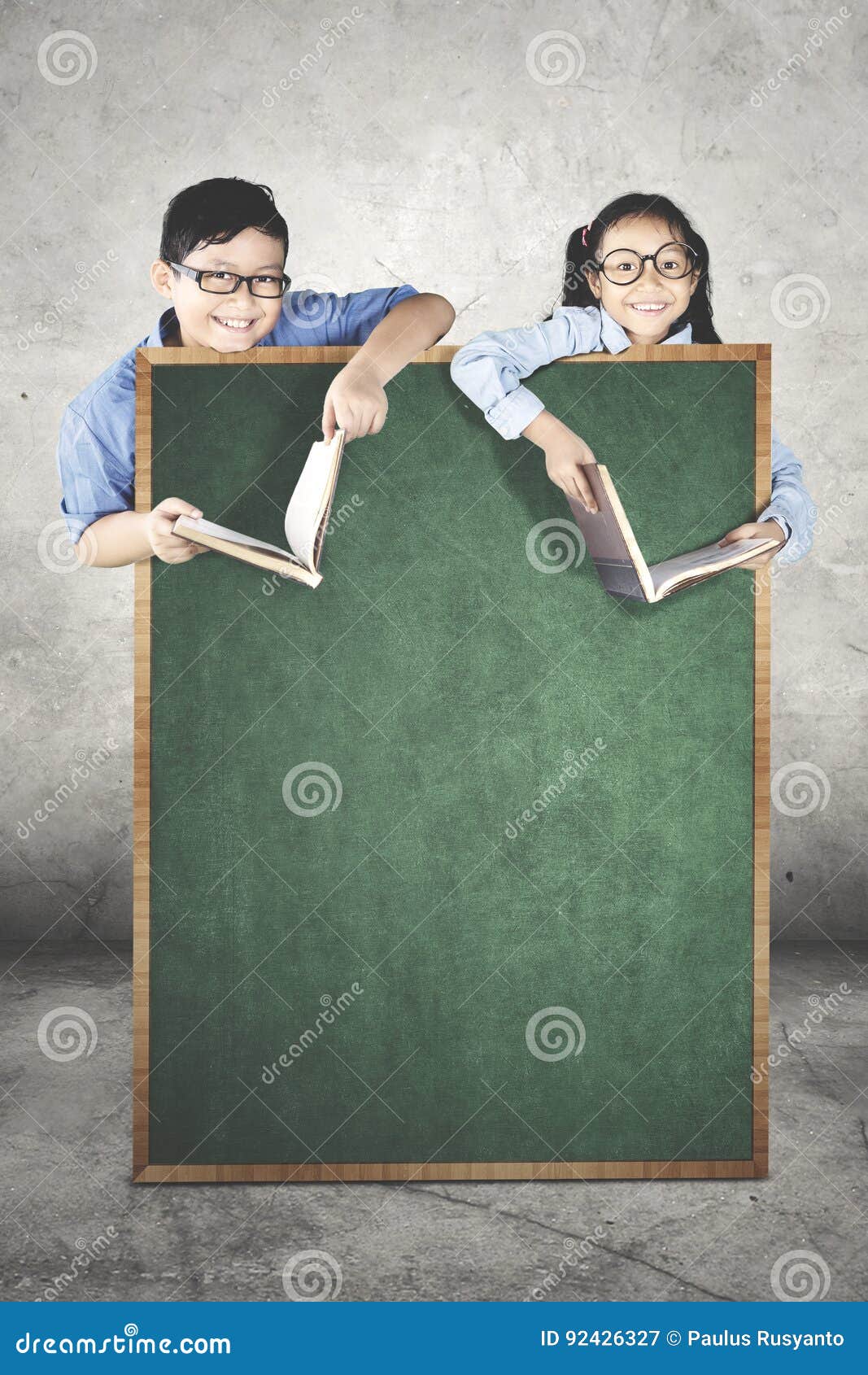 Elementary Students with Book Behind a Chalkboard Stock Image - Image ...