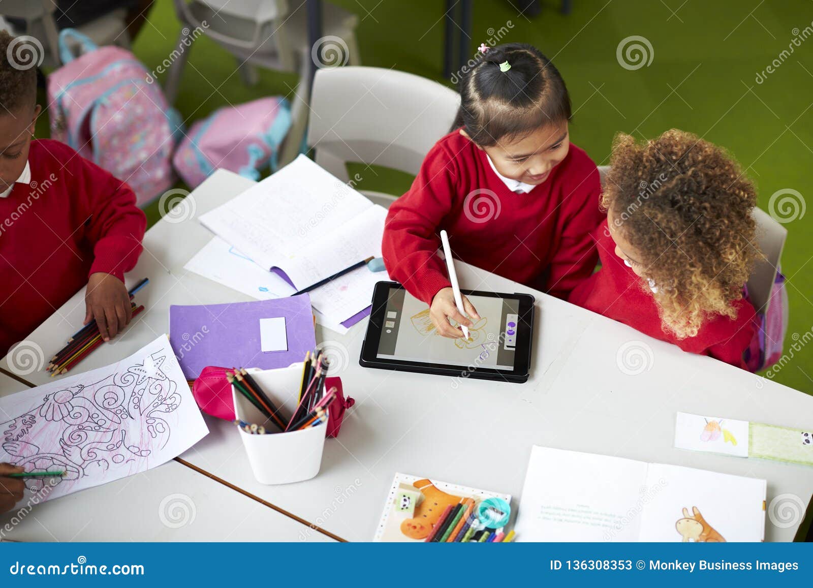 Elevated View of Two Infant School Girls Sitting at a Table, Using a ...