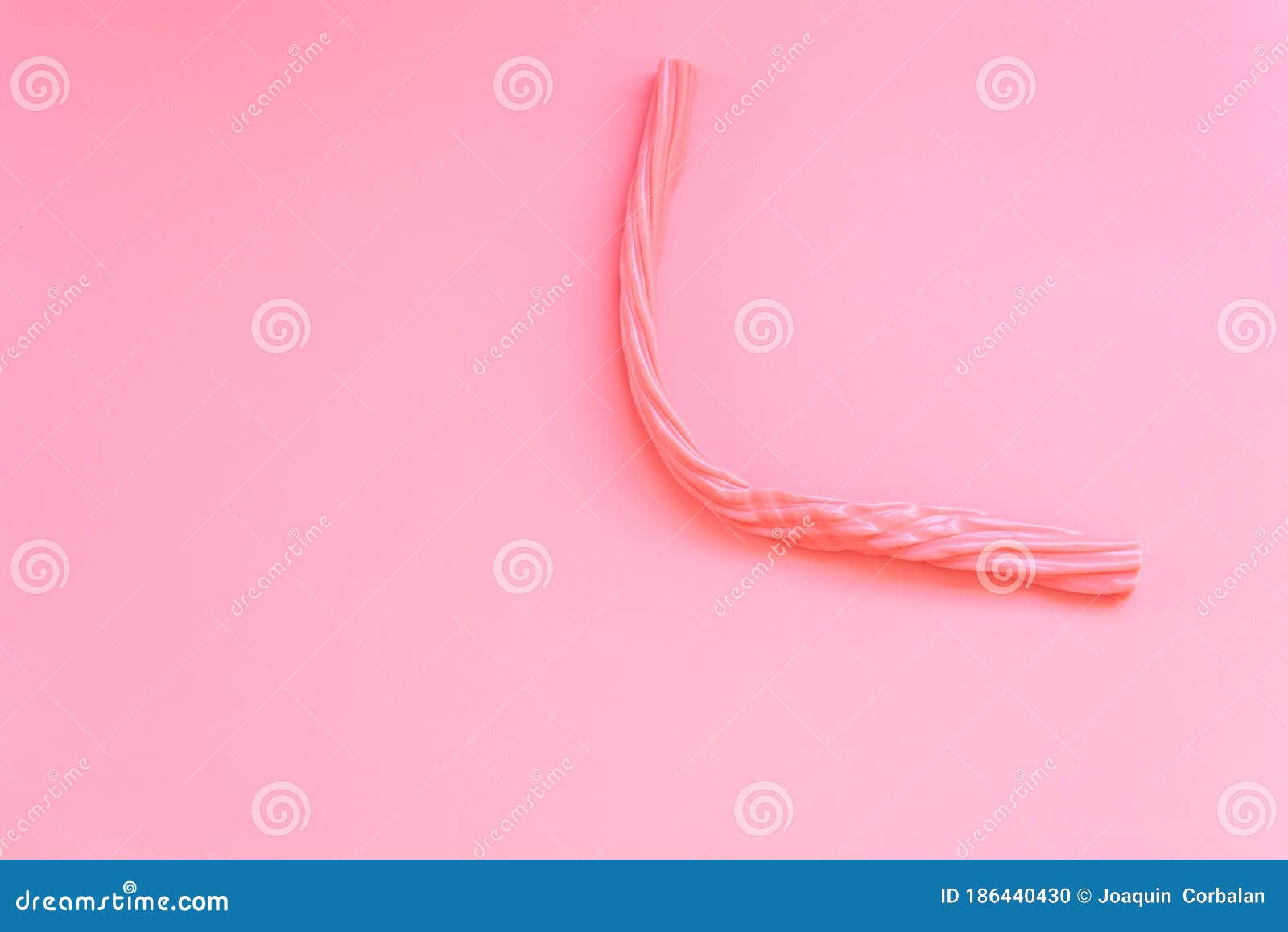 Elongated Pink Candy Isolated on a Flat Colored Background Stock Photo ...