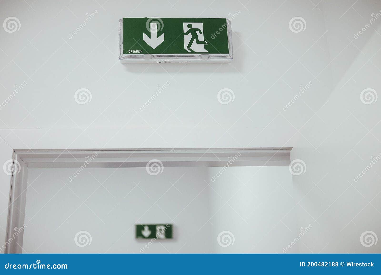 Exit sign on a white wall stock photo. Image of safety - 200482188