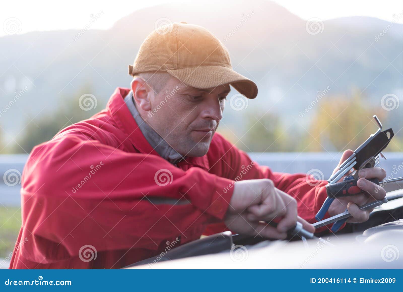 Emergency Roadside Assistance, Road Assistance Worker in Uniform Trying ...