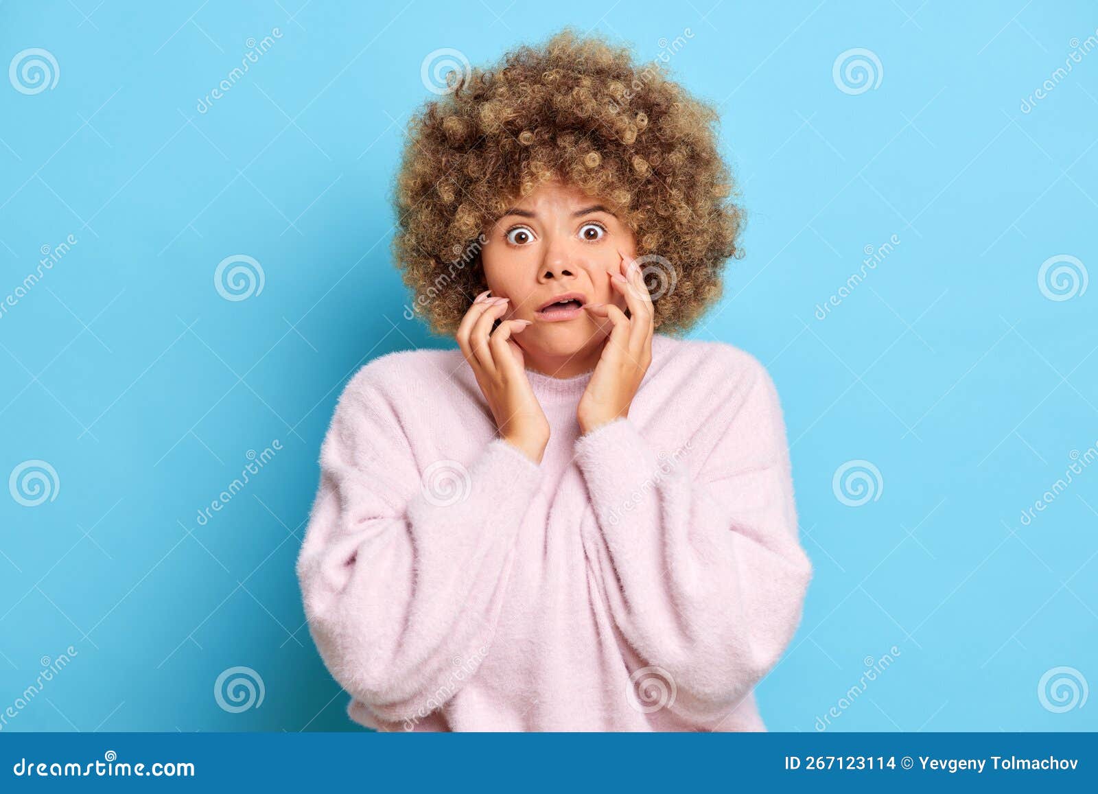 Emotional Adult Woman With Curly Hair Stares In Shocked And Nervous