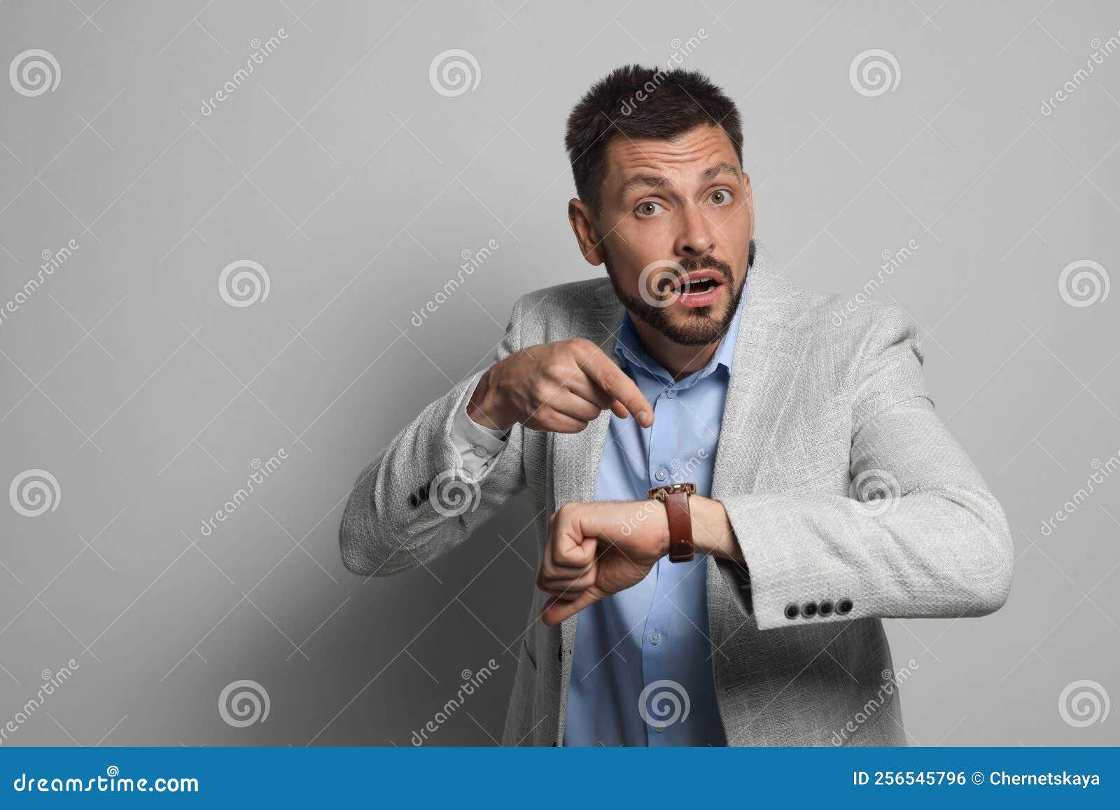 Emotional Man Checking Time on Grey Background, Space for Text. Being ...
