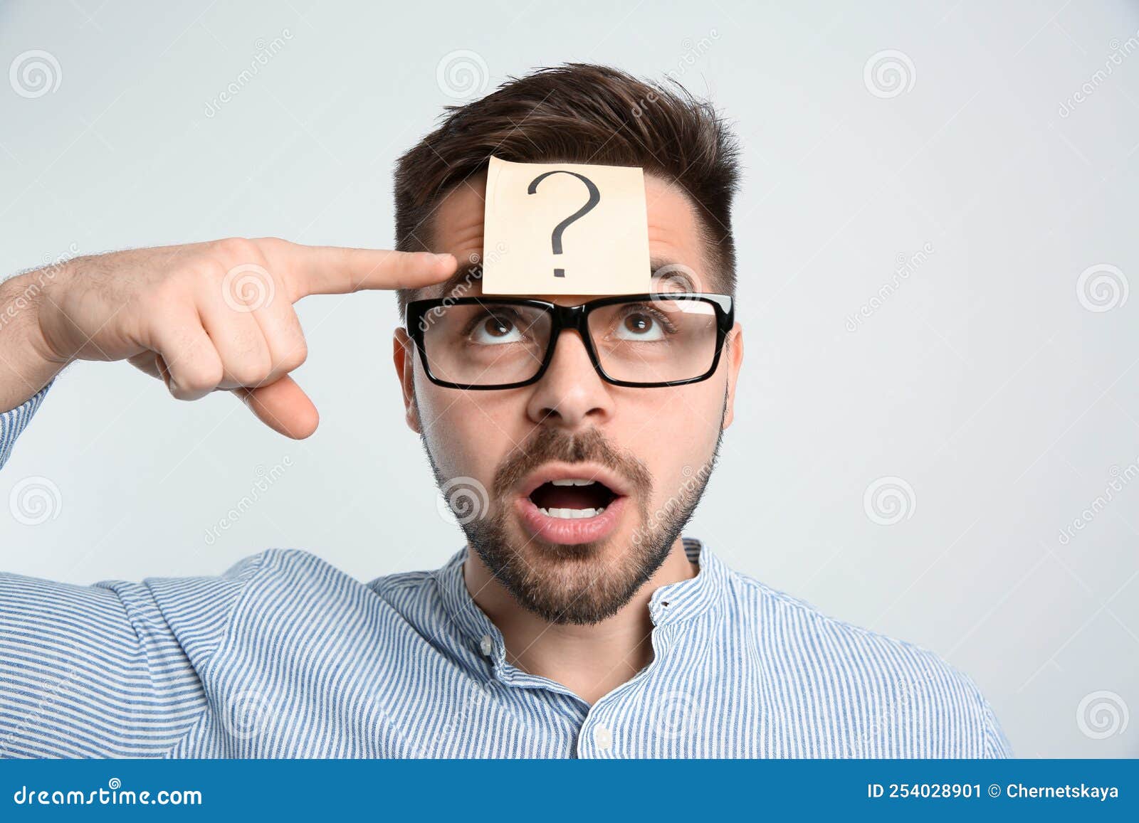 Emotional Man with Question Mark Sticker on Forehead Against Light ...