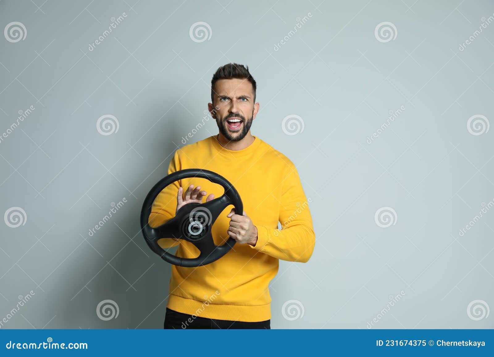 Emotional Man with Steering Wheel on Grey Background Stock Image ...