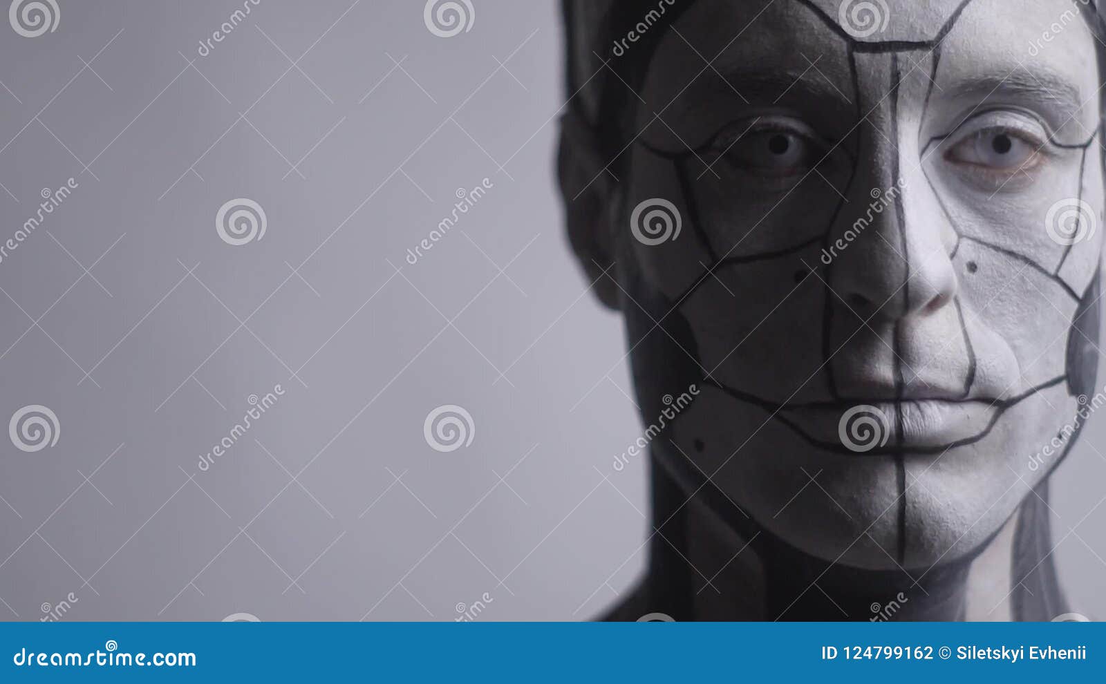 An Emotionless Robot Stands on a Gray Background and Blinks Stock ...