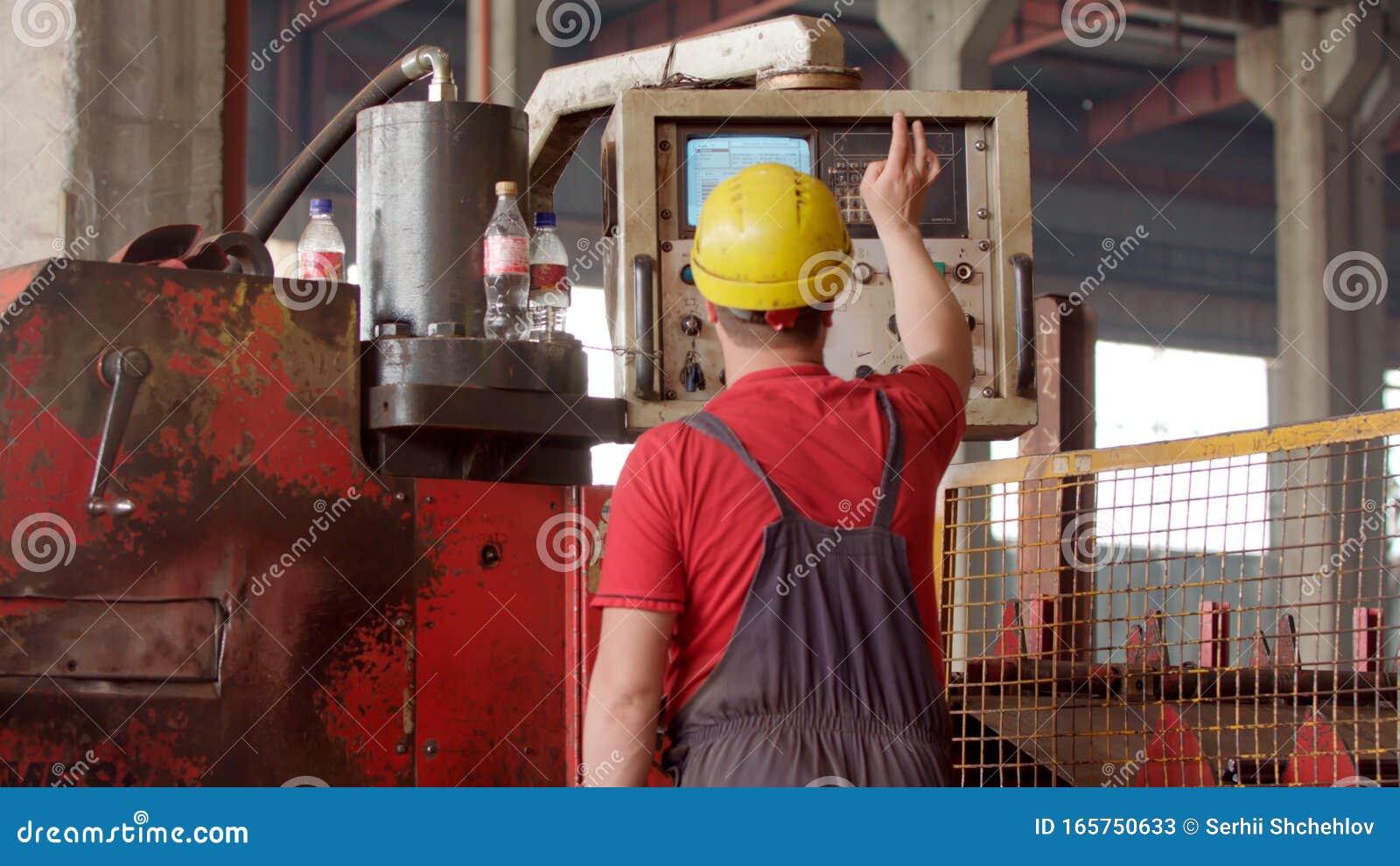 An Employee in Helmet Operating a Metal Processing Machine Editorial ...
