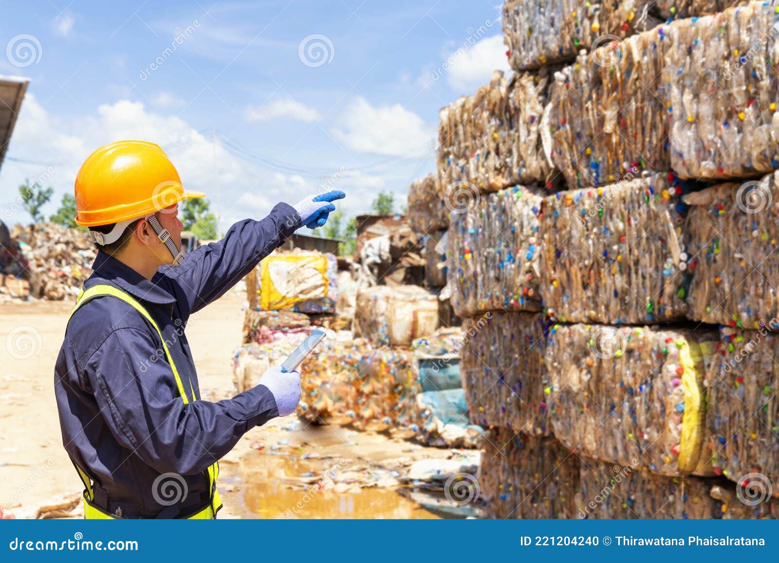 An Employee at a Recycling Plant is Pointing To Plastic Waste Being ...