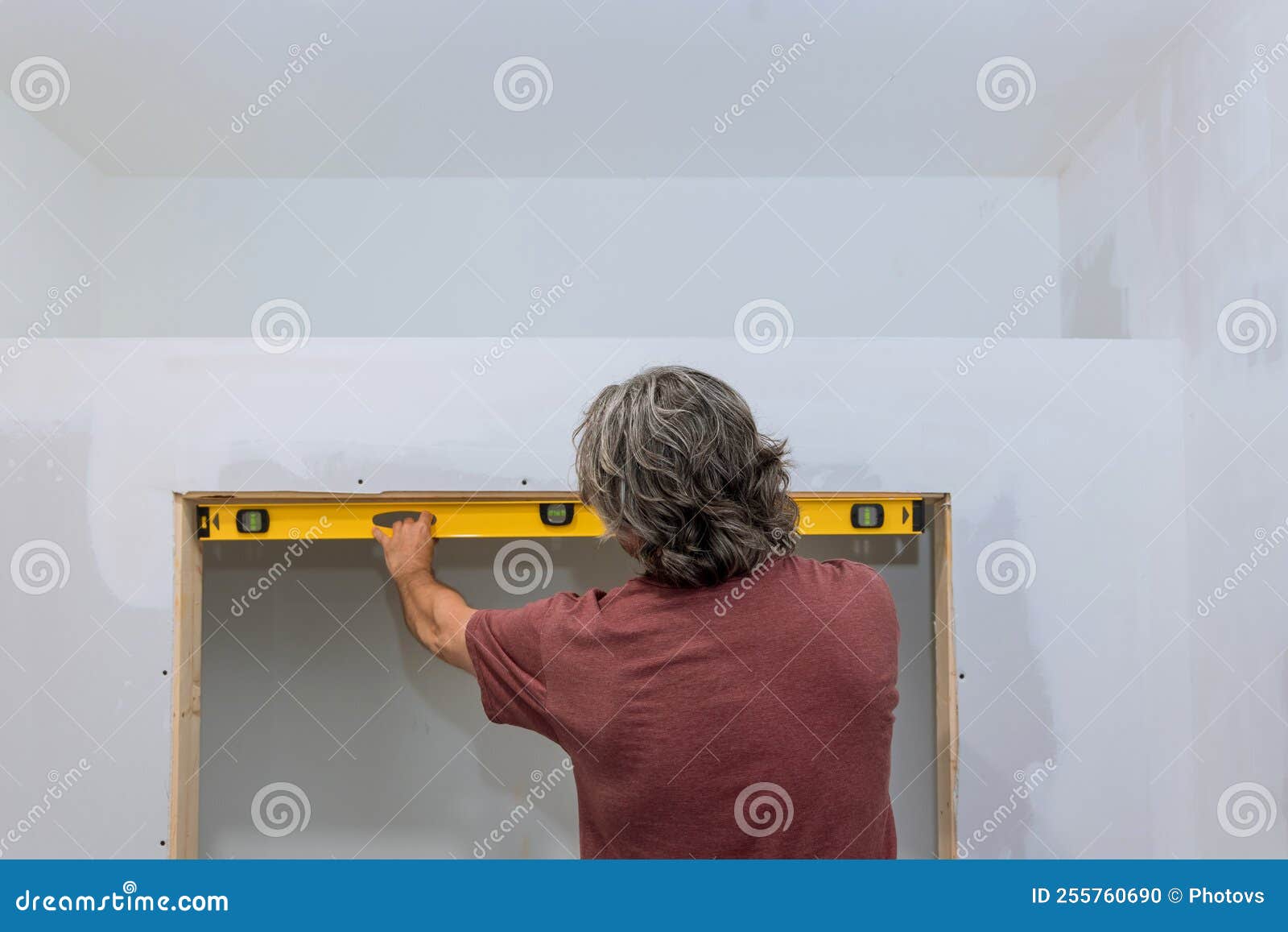 An Employee Uses a Level To Evaluate the Equality of a Wall of Openning ...