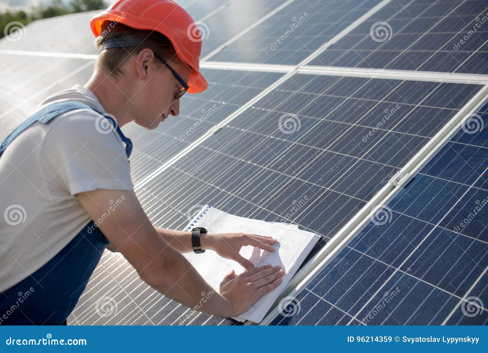 An Employee Of The Solar Station Holds A Laptop, Standing Next To The ...