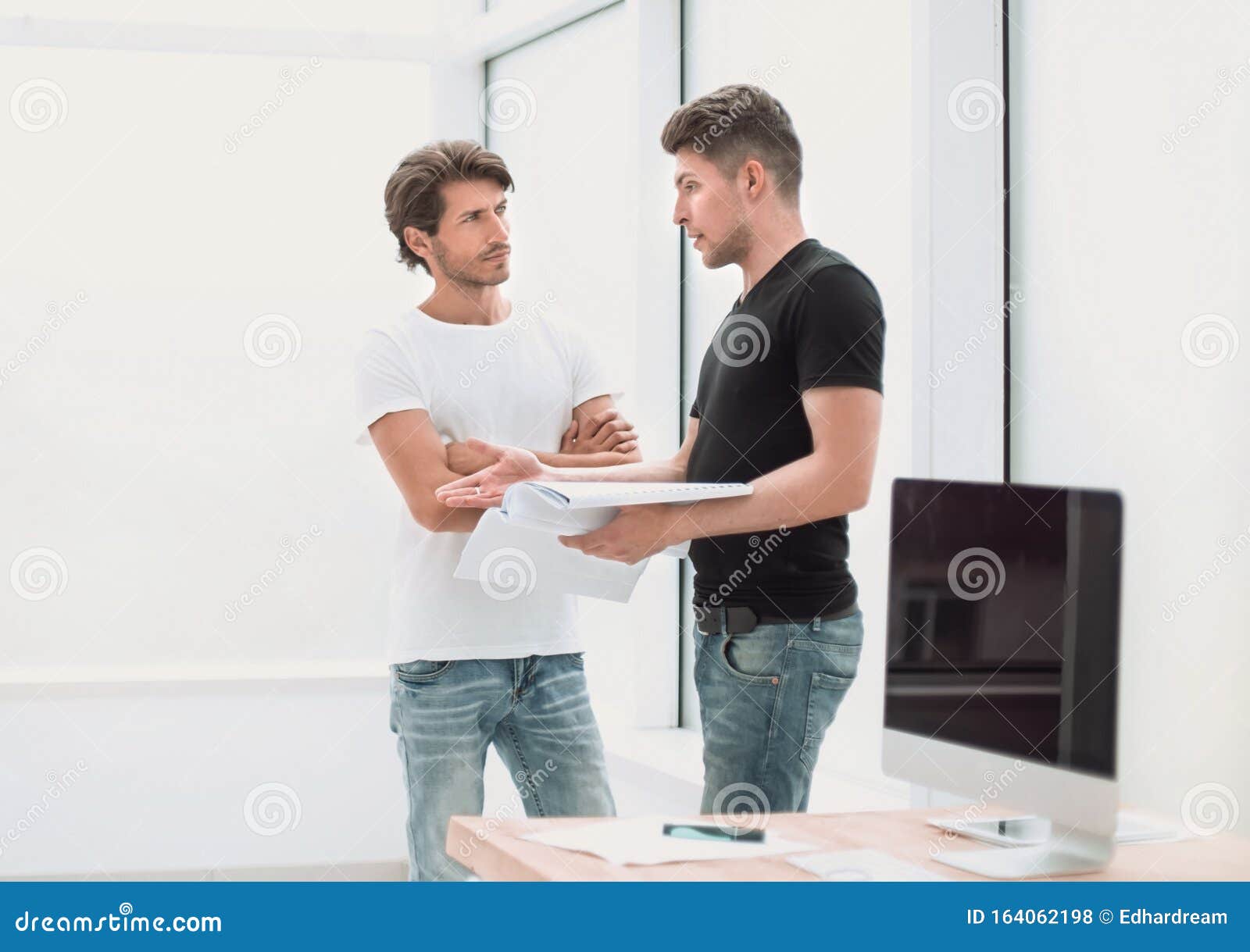 Employees Discuss Documents Standing in a Spacious Office Stock Photo ...