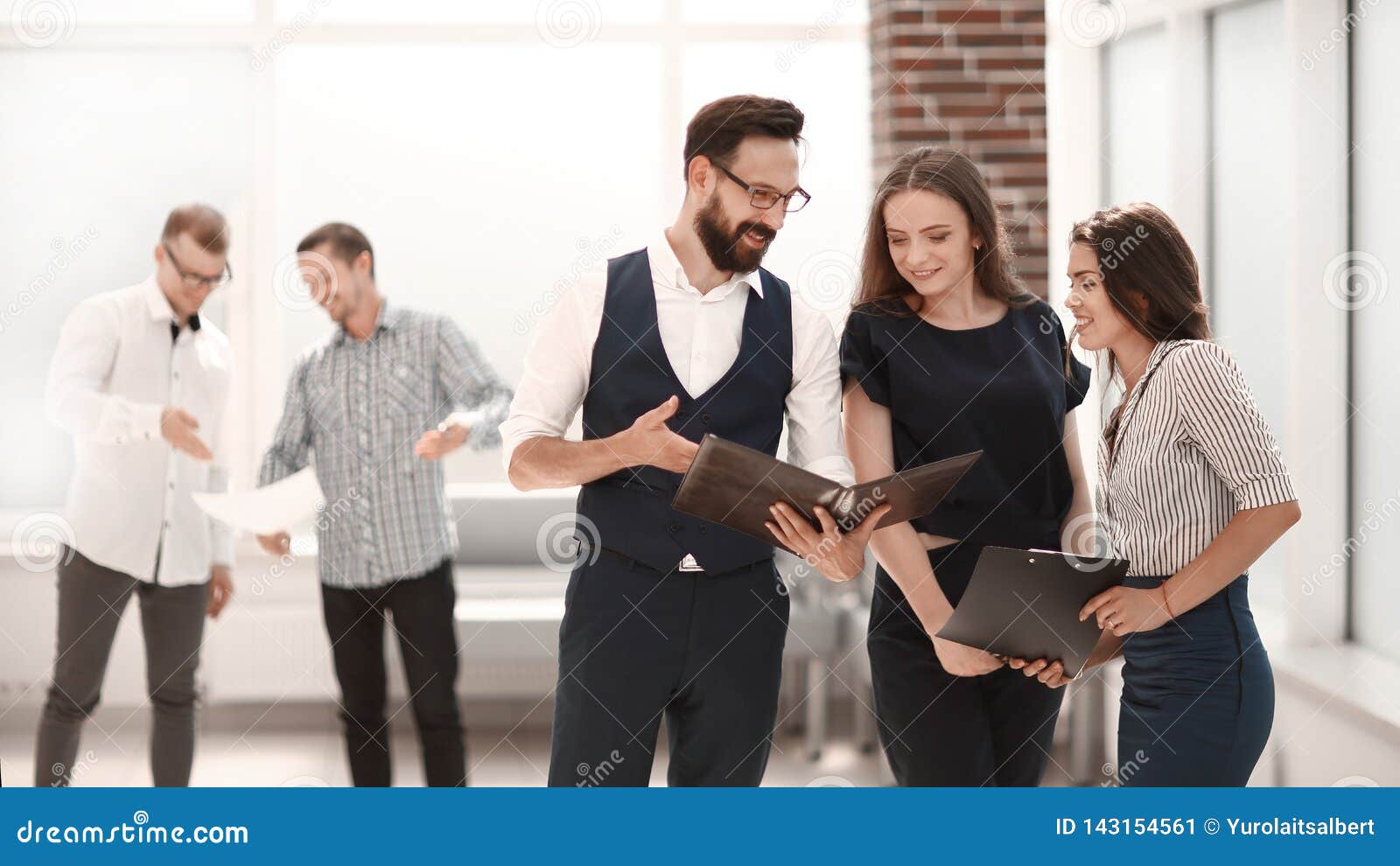 Employees Discussing Working Documents, Standing in the Office Lobby ...