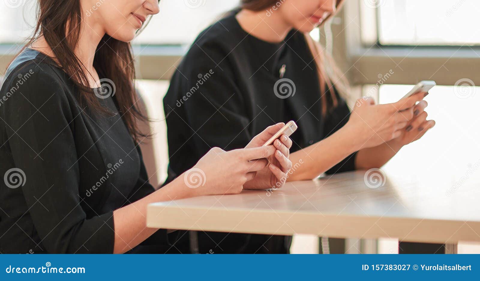 Employees Using Their Smartphones Sitting at a Table in a Cafe Stock ...