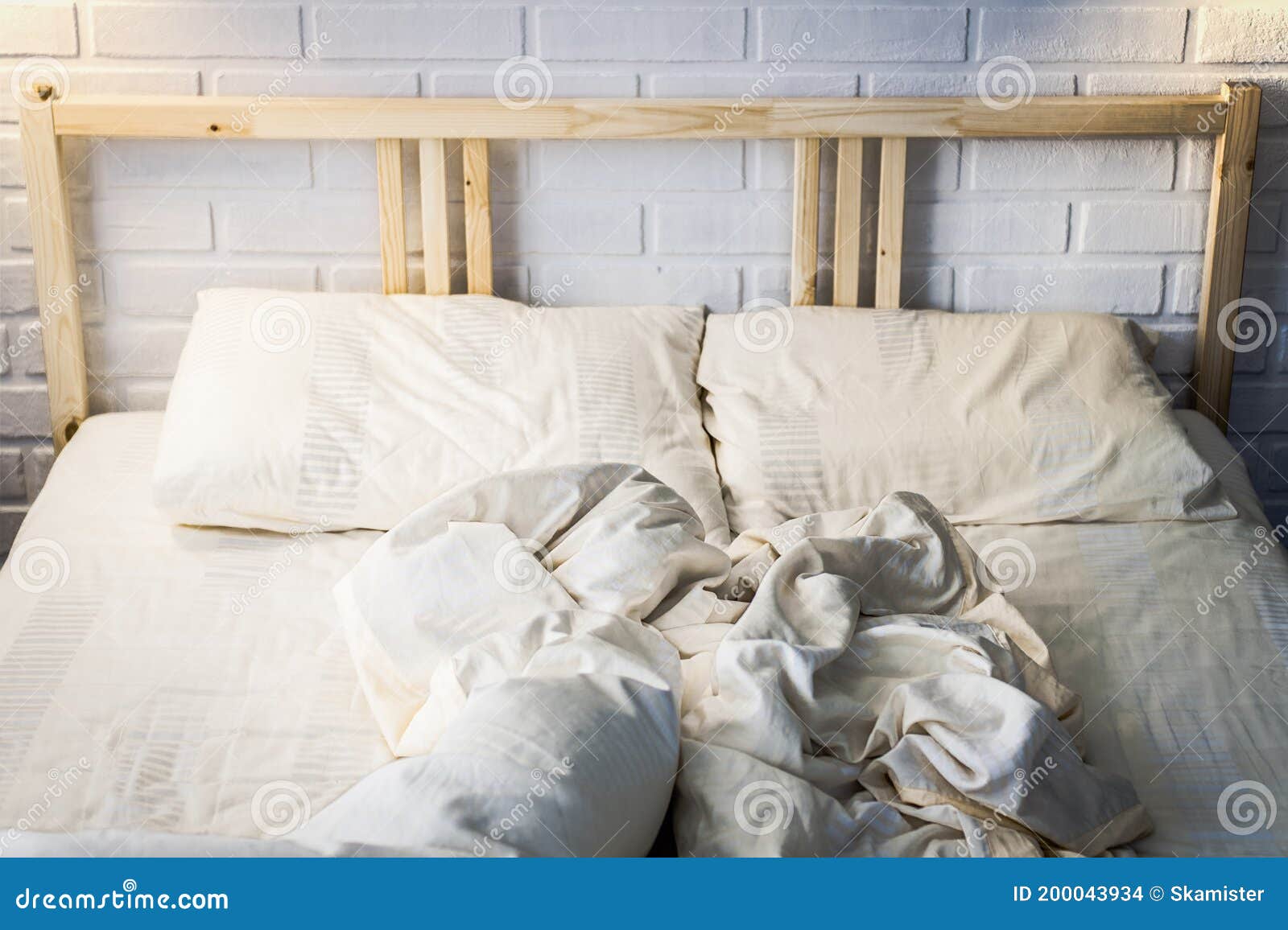 Empty Wooden Bed in the Bedroom, with Unmade Light Duvet Stock Photo ...