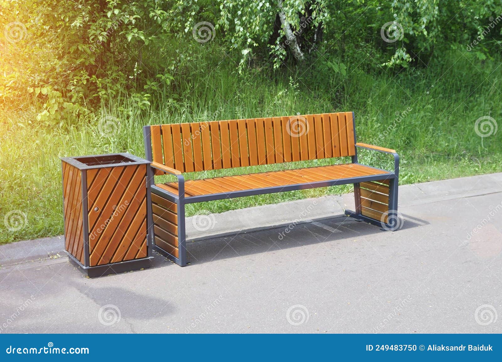 An Empty Bench in the Park Near the Footpath and a Trash Can Stock ...