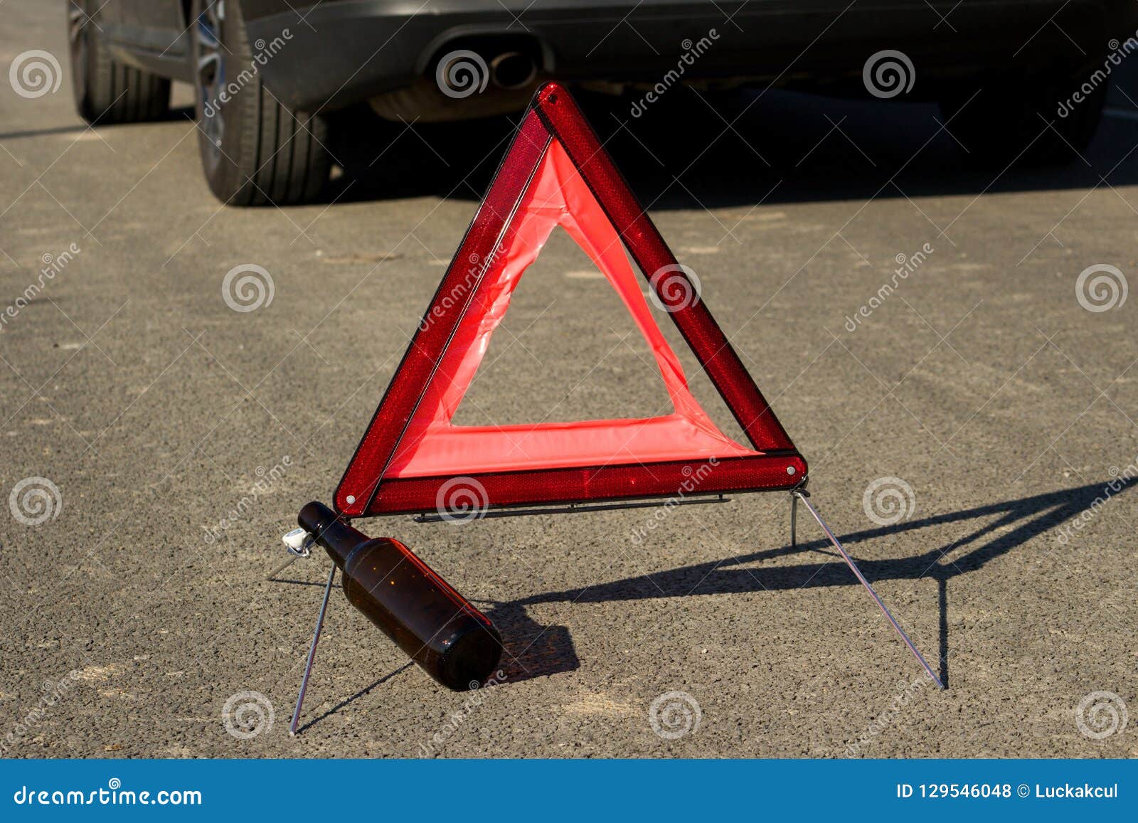 An Empty Bottle of Beer or Other Alcohol and a Warning Triangle. Stock ...