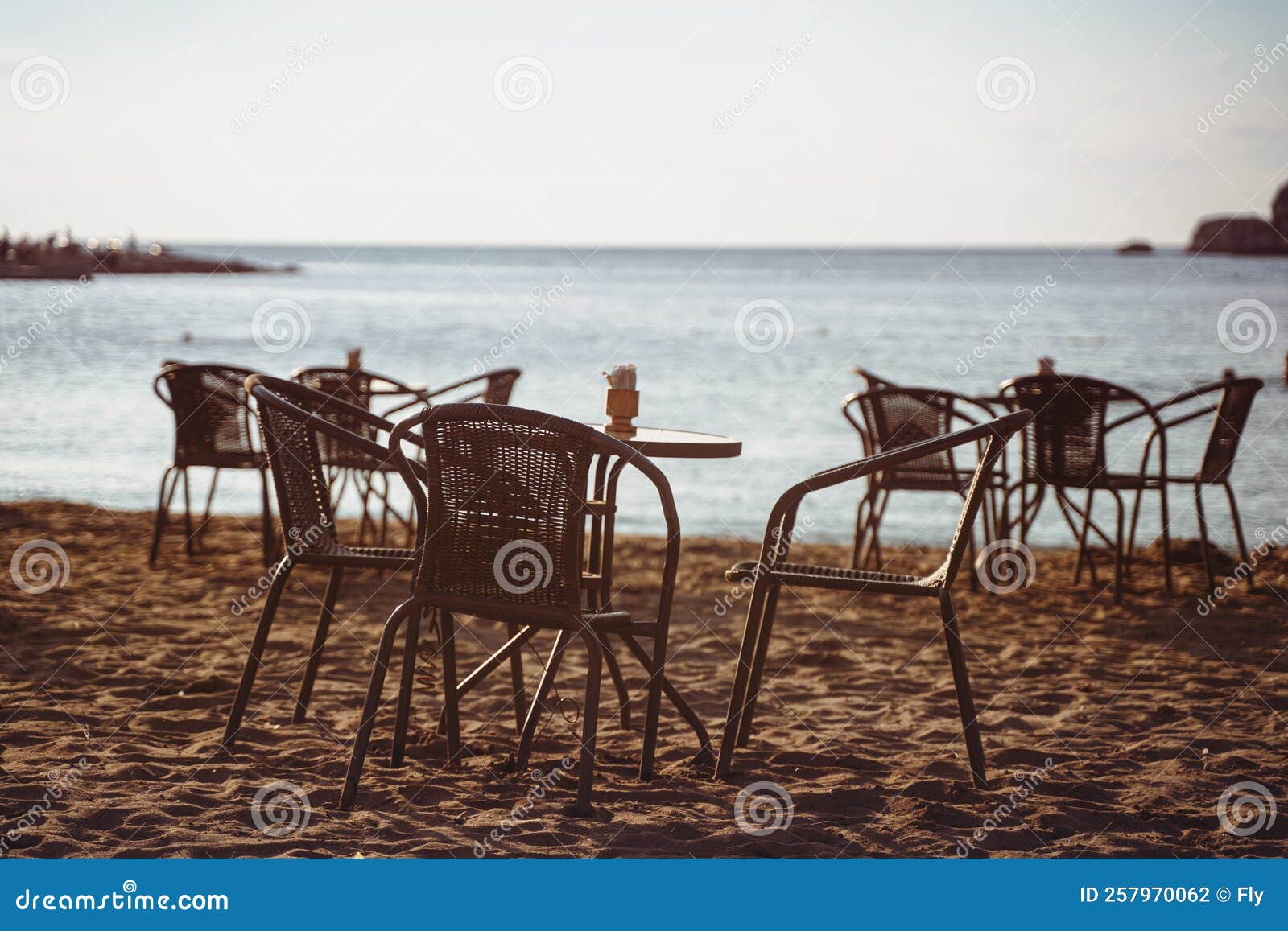 Empty Cafe Table and Chairs on Sandy Beach in Front of Sea Golf with ...