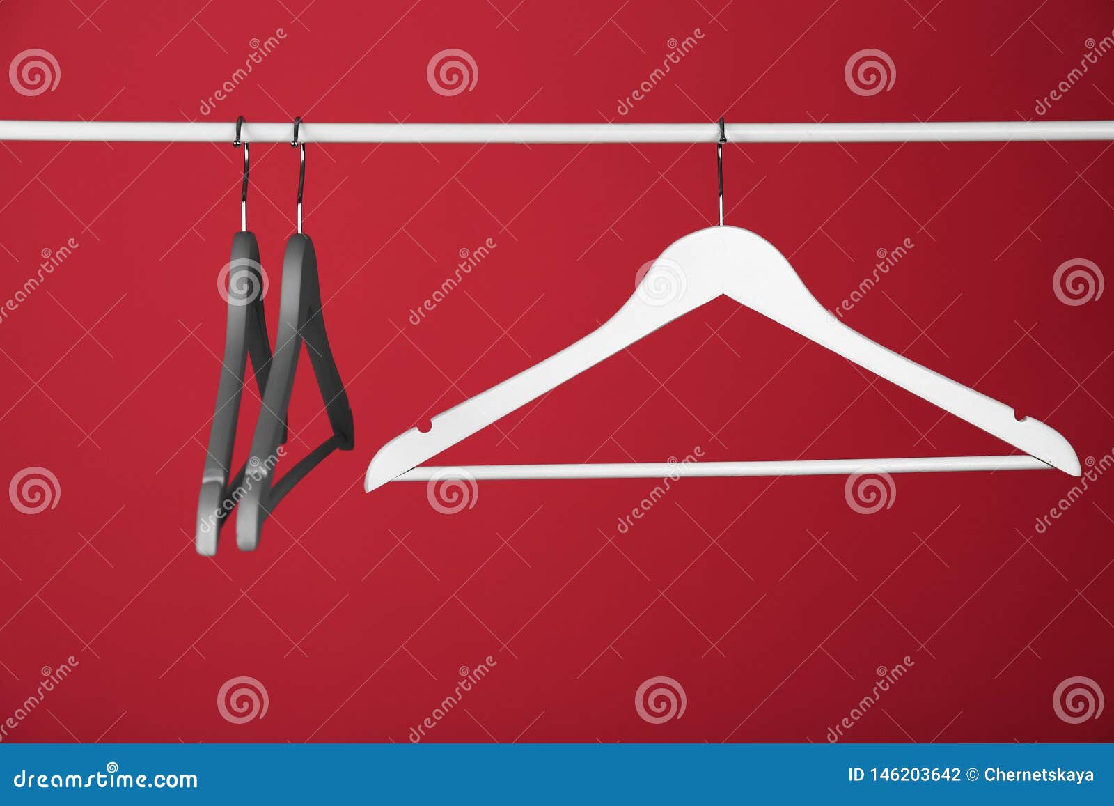 Empty Clothes Hangers on Metal Rail Against Color Background Stock ...