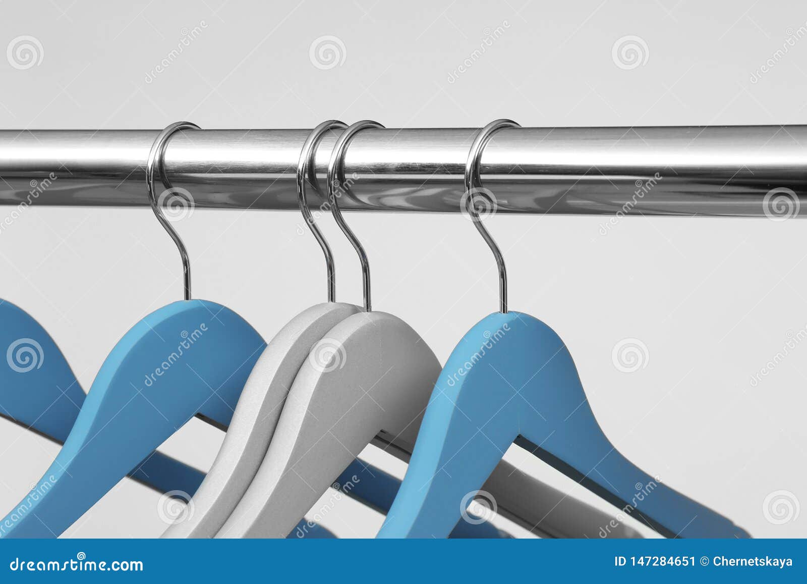 Empty Clothes Hangers on Metal Rail Against Light Background Stock ...